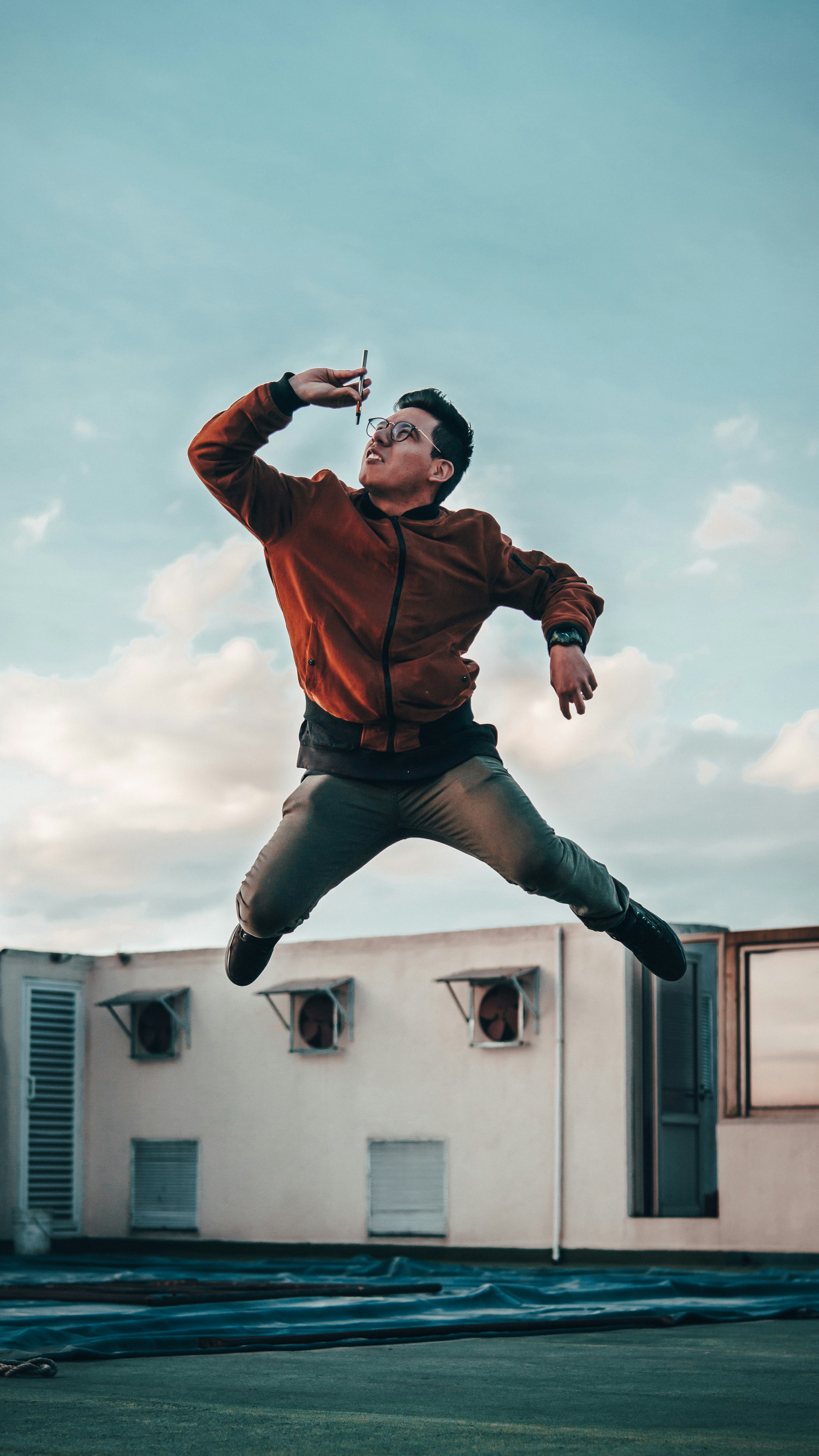 Man jumping while holding pen photo – Free Human Image on Unsplash