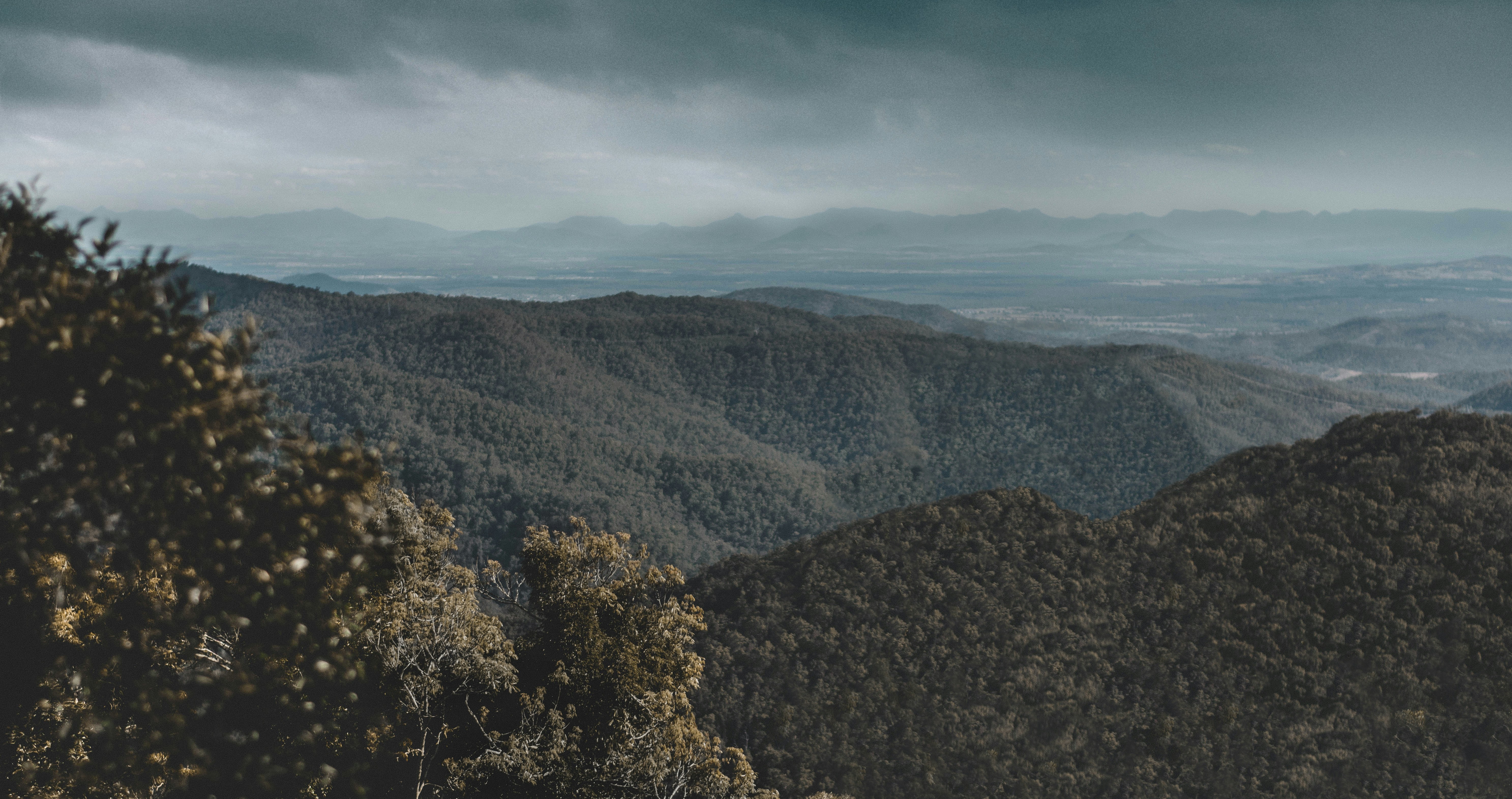 Expansive view of lush green mountains under a moody sky.