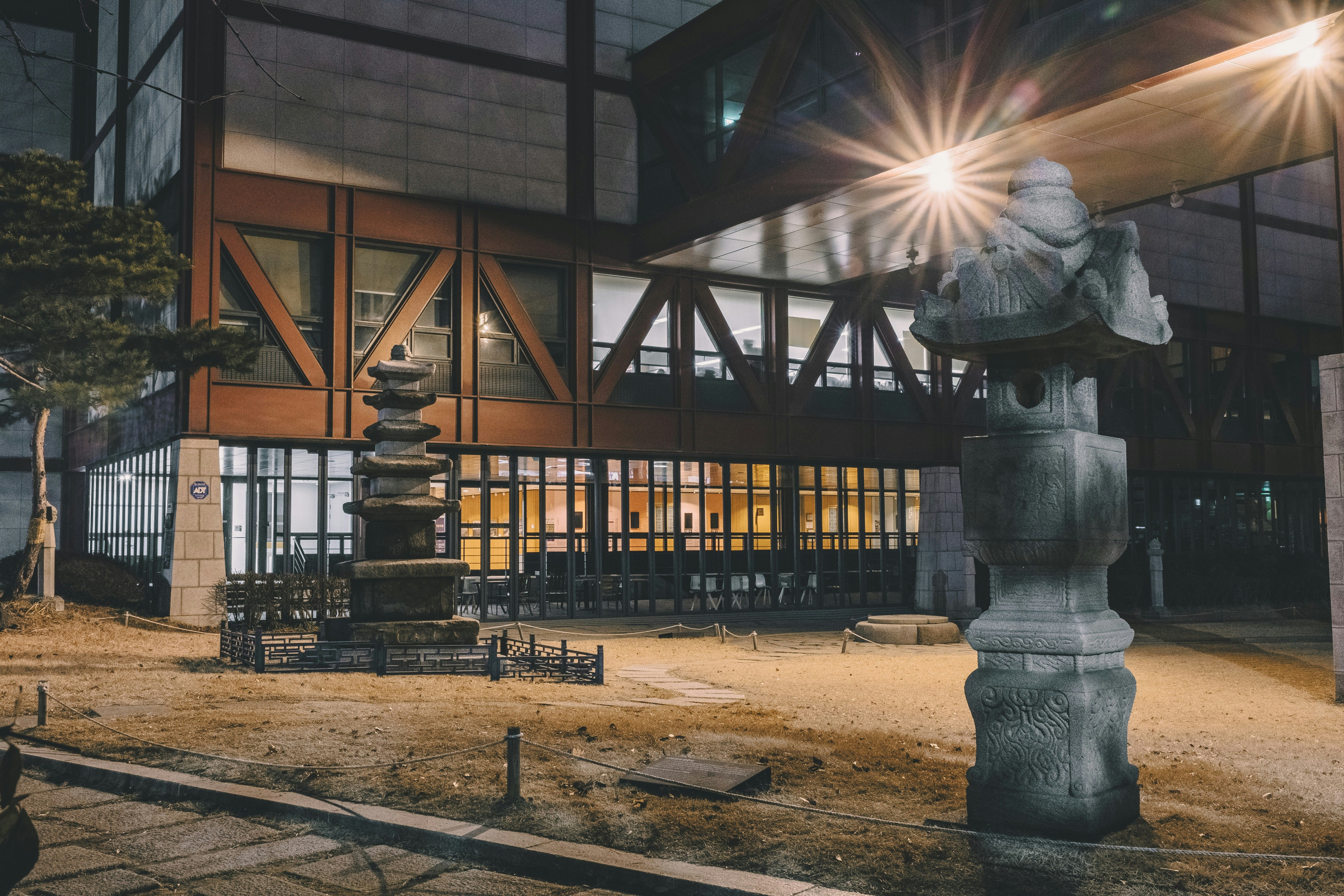 Stone Lanterns at Night: A Quiet Courtyard Framed by Glass and Timber