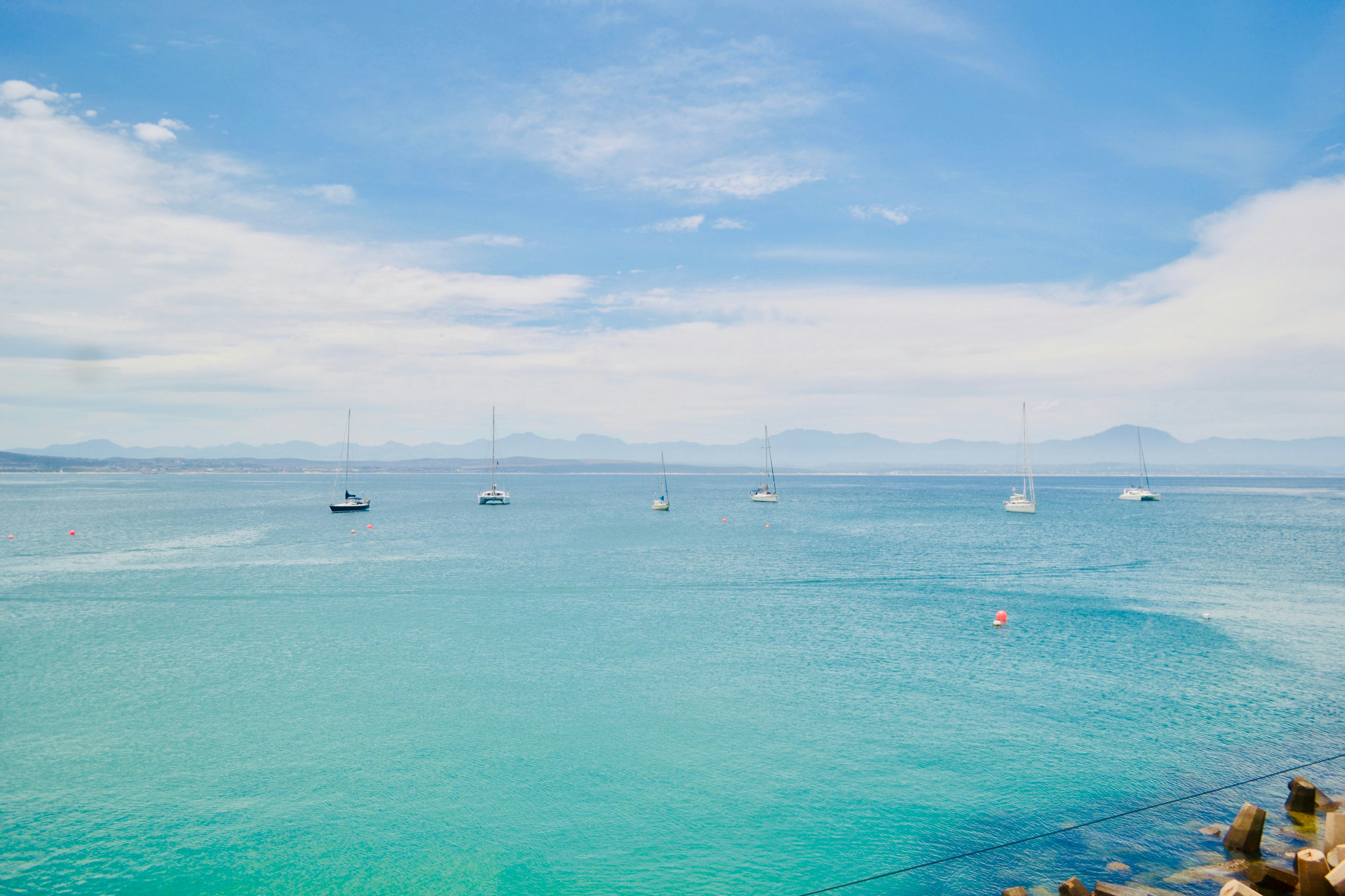 Foto Barcos en mar en calma bajo cielos azules y blancos – Imagen ...