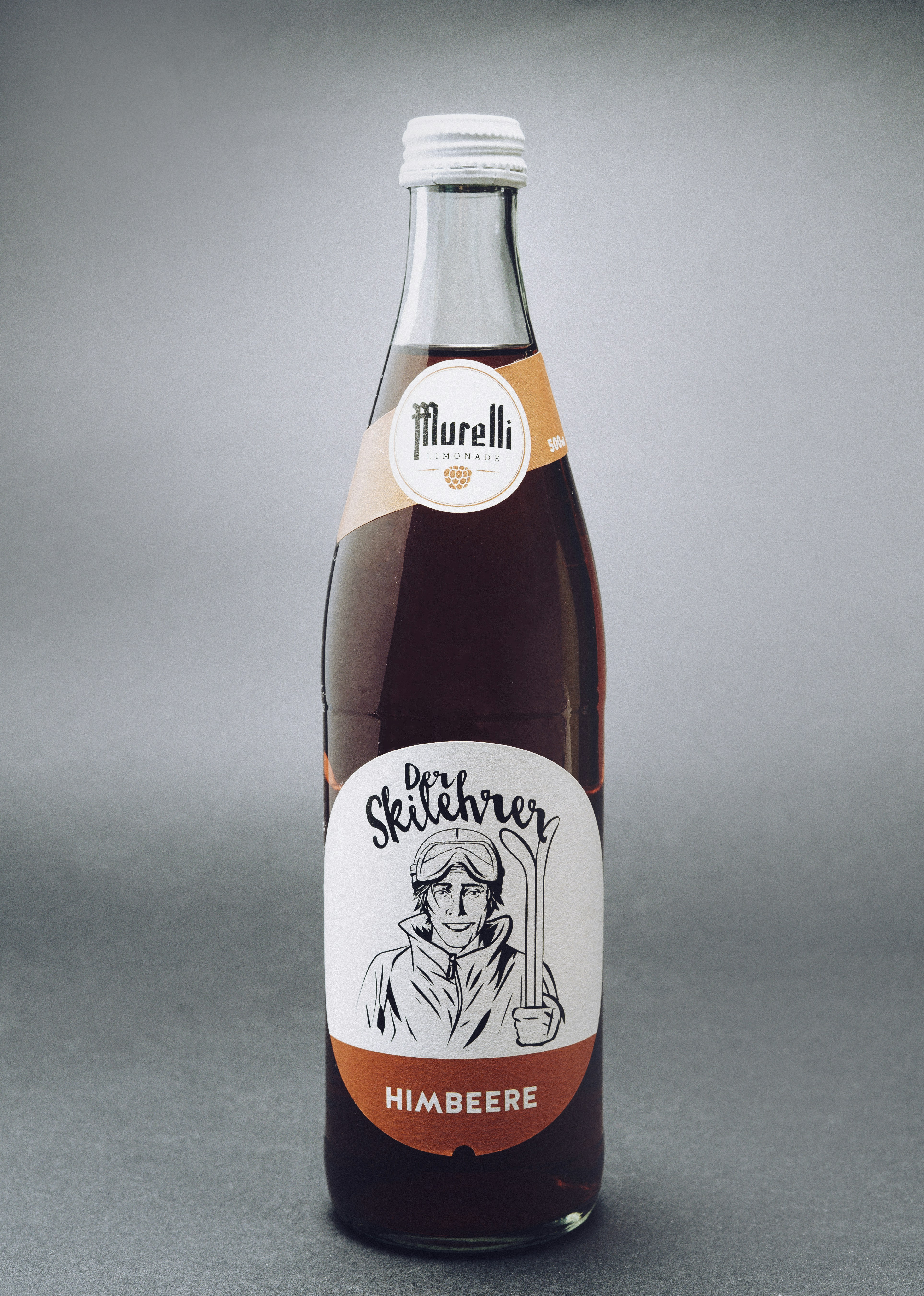 A bottle of Morelli Himbeere lemonade featuring a vintage illustration of a skier on its label, set against a muted gray background.