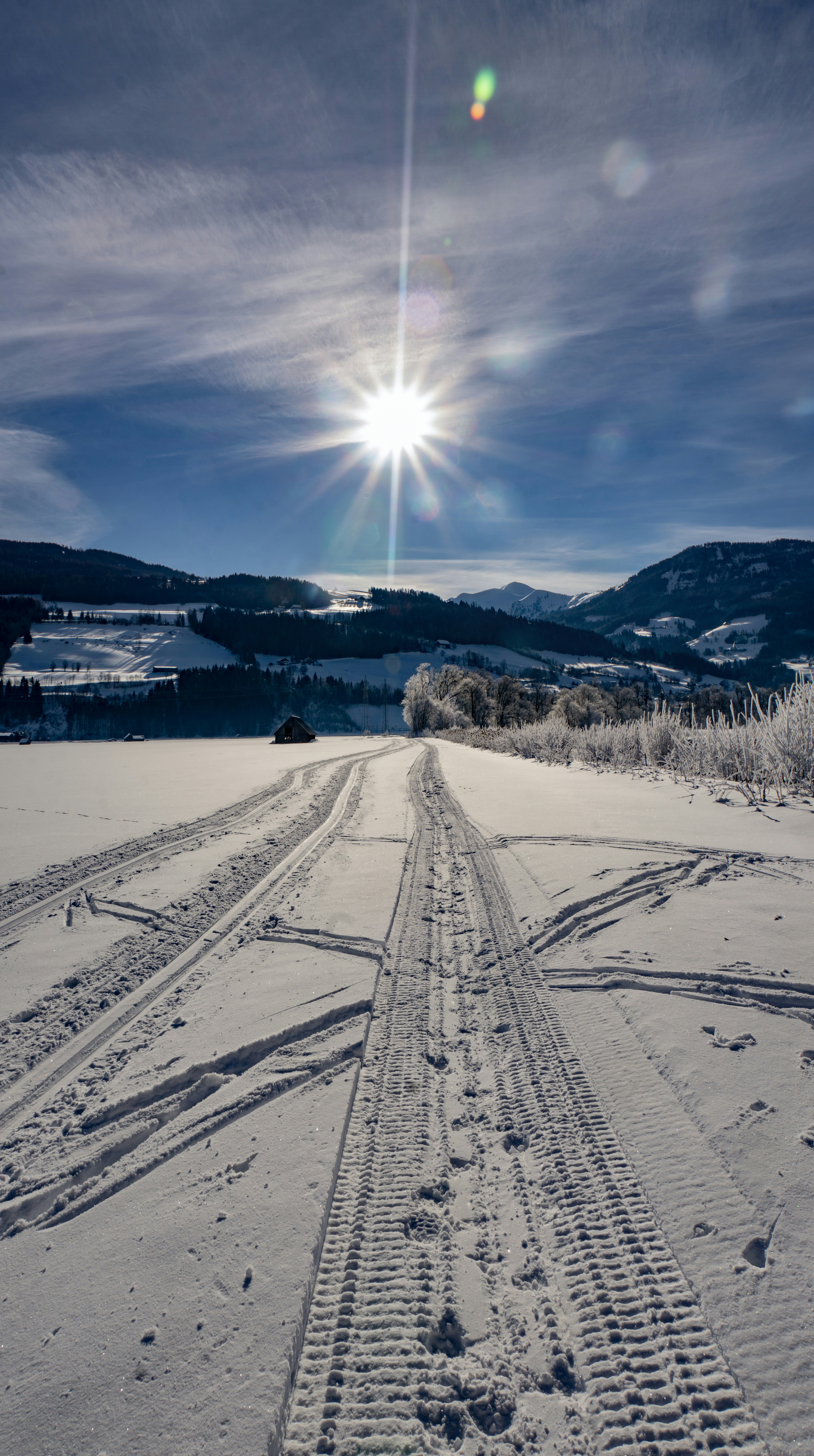 Sunlit Snowbound Path Toward Distant Peaks