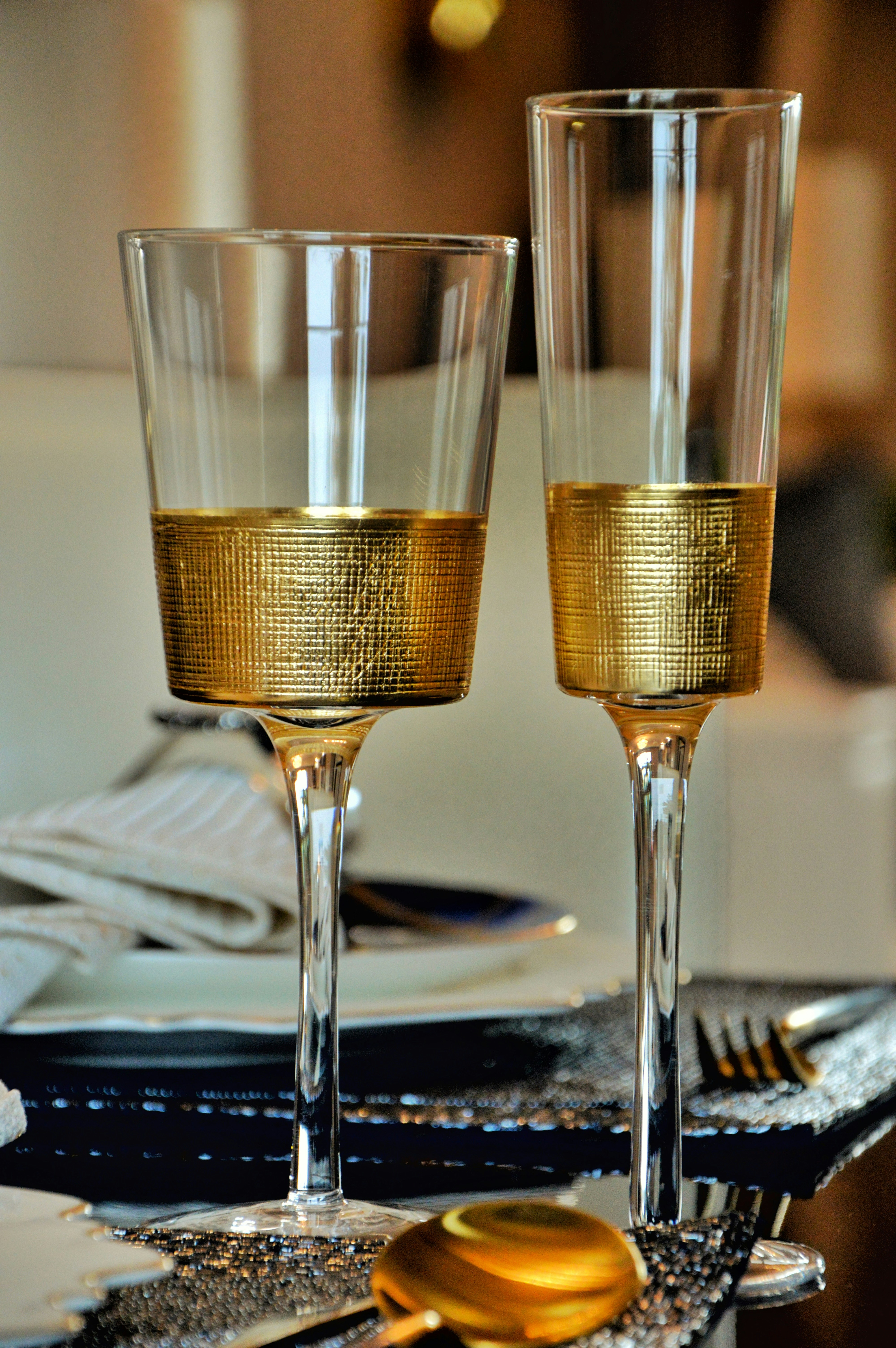 Twin Gold-Rimmed Champagne Flutes Anchoring a Warm Dinner Table Moment