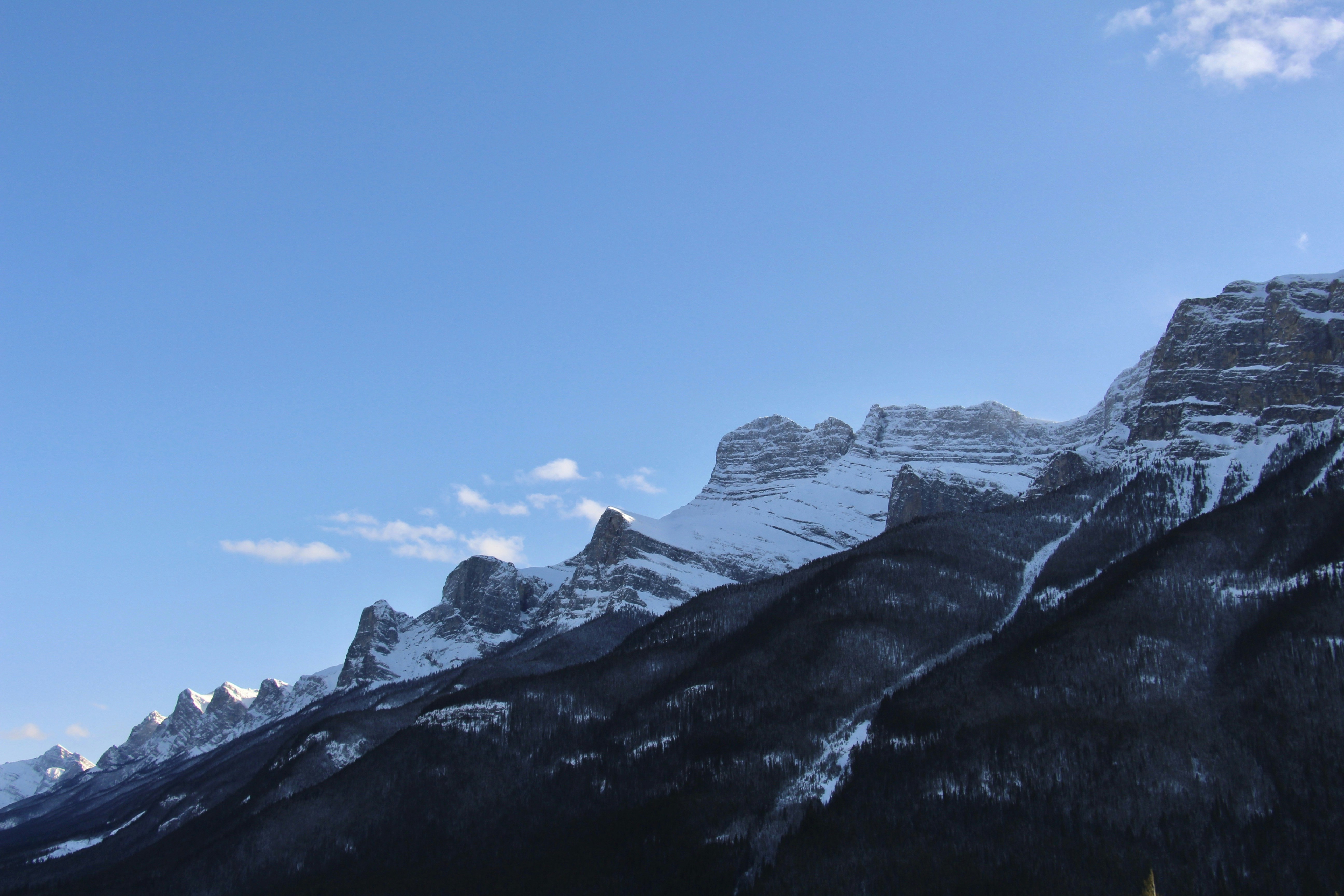 Snow-capped mountain range beneath a clear blue sky.