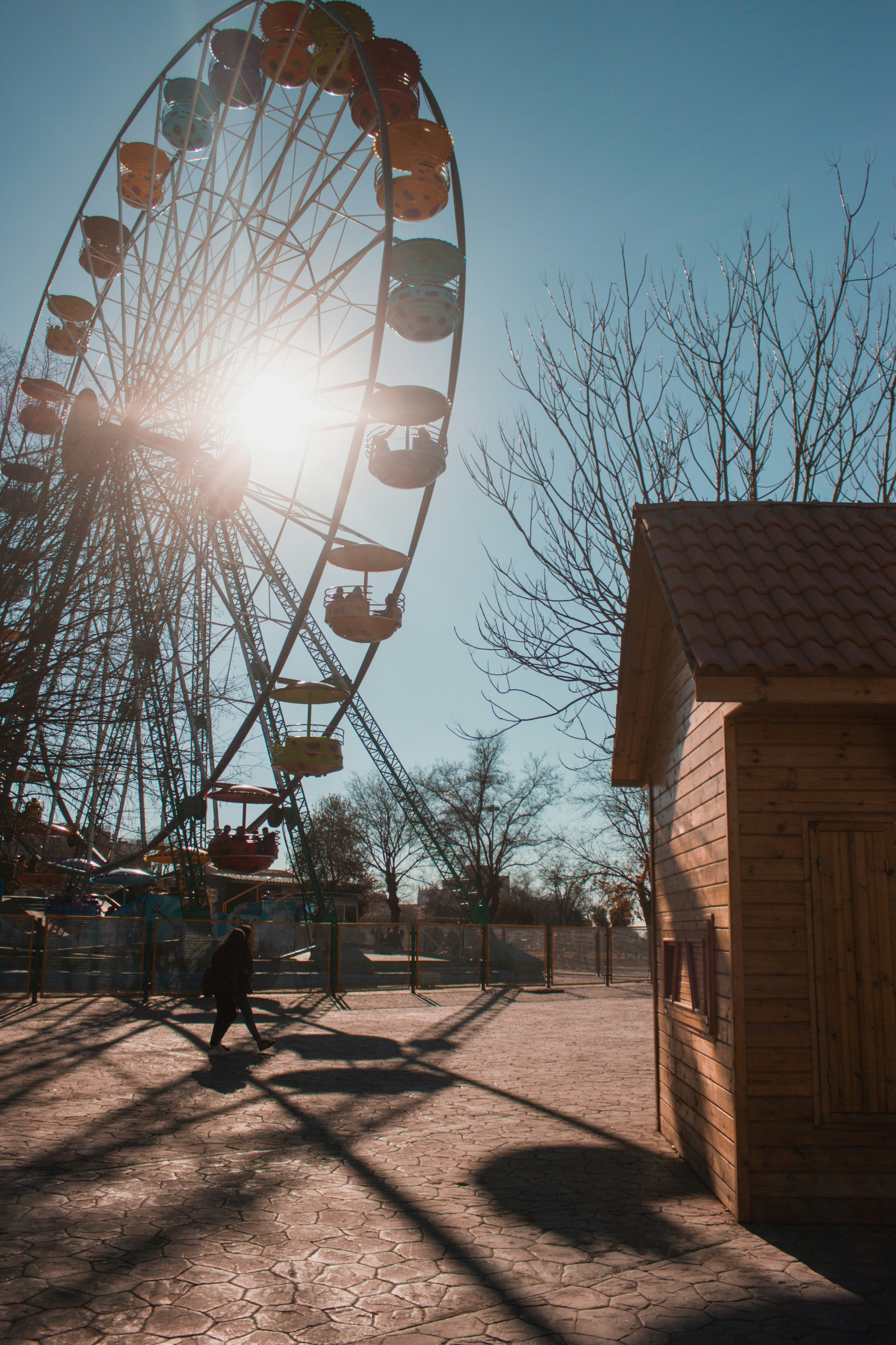 Sunlit Spin: Ferris Wheel and Long Park Shadows