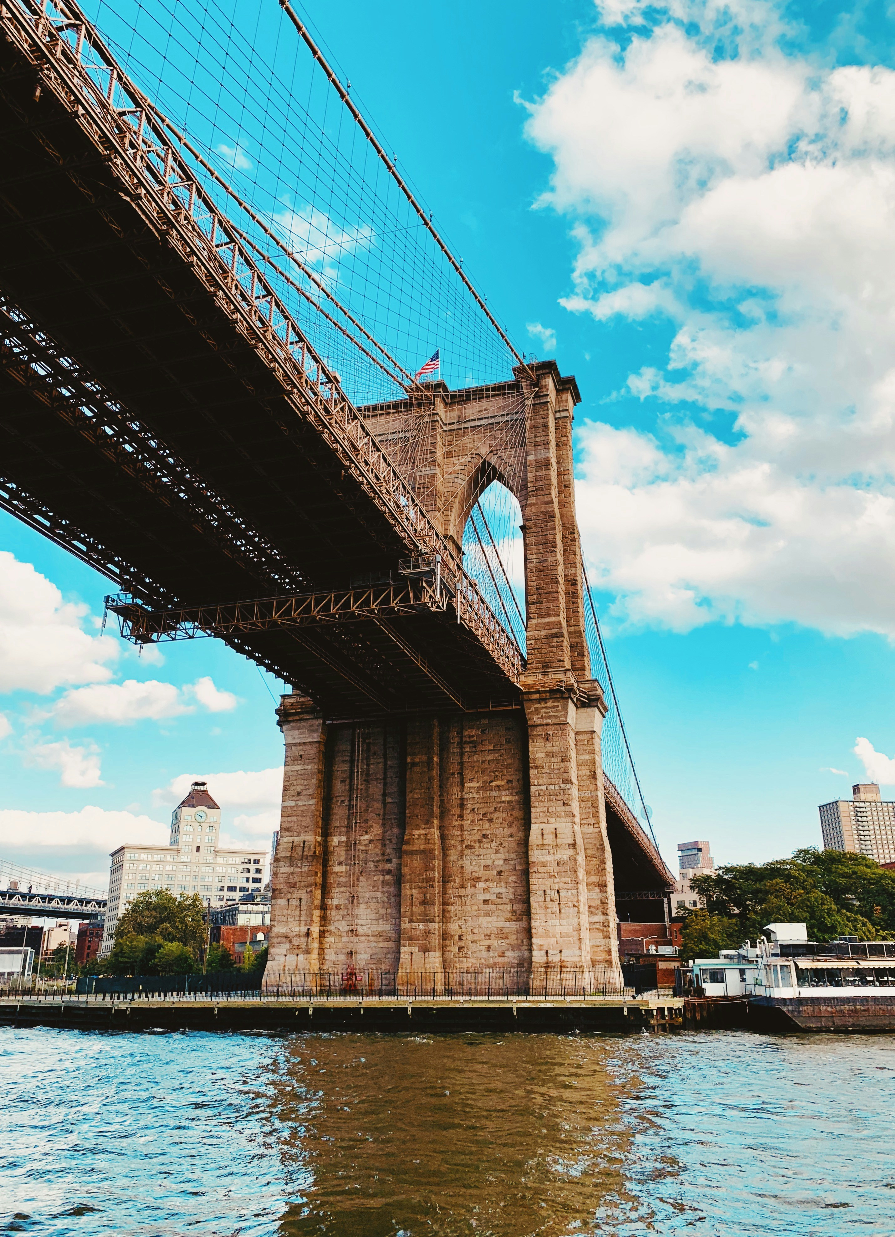 Brooklyn Bridge Tower in Bright Day: Steel Ribbons and Stone Against the River