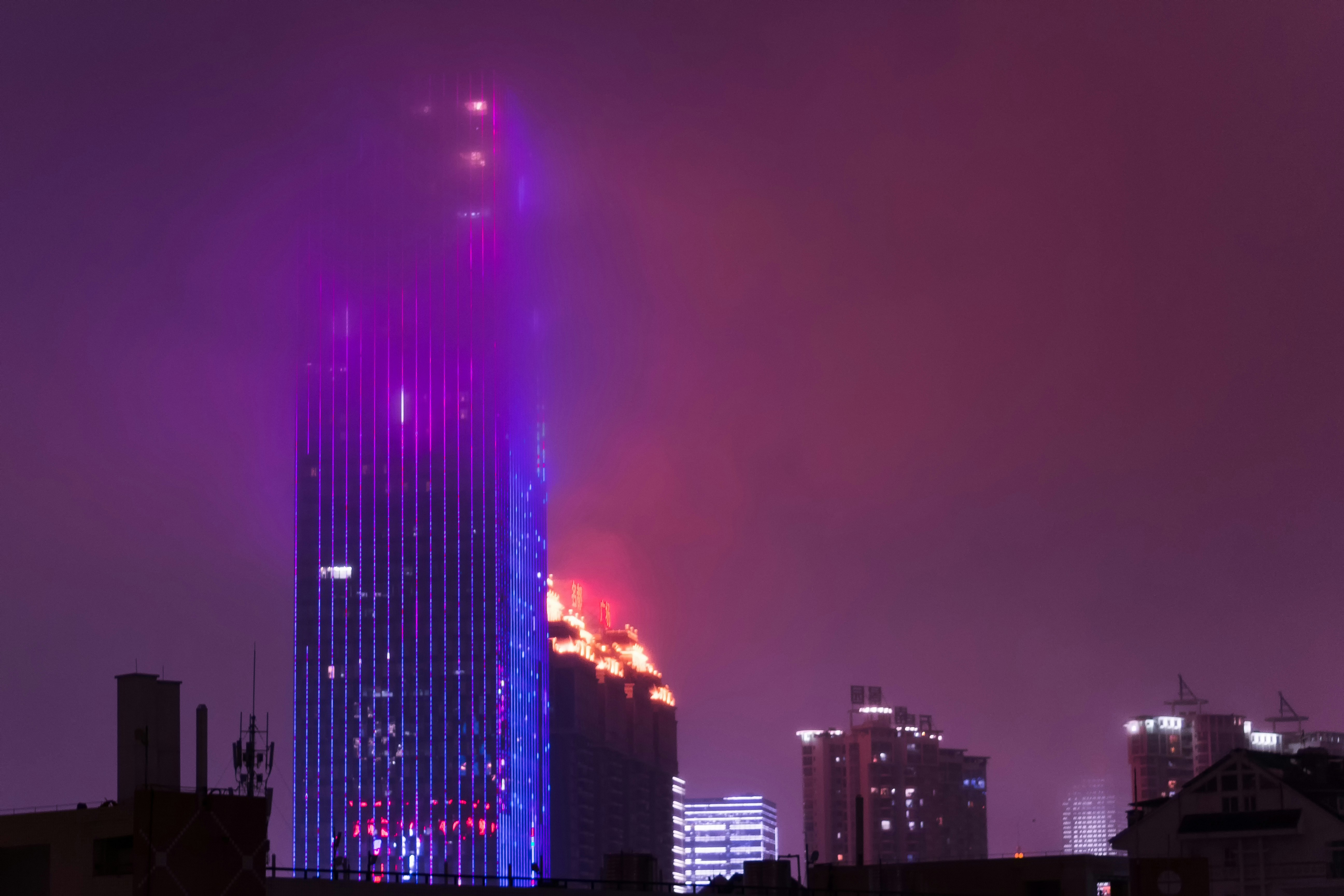 Neon Spire Piercing the Night Fog: A Purple-Tinted Skyline