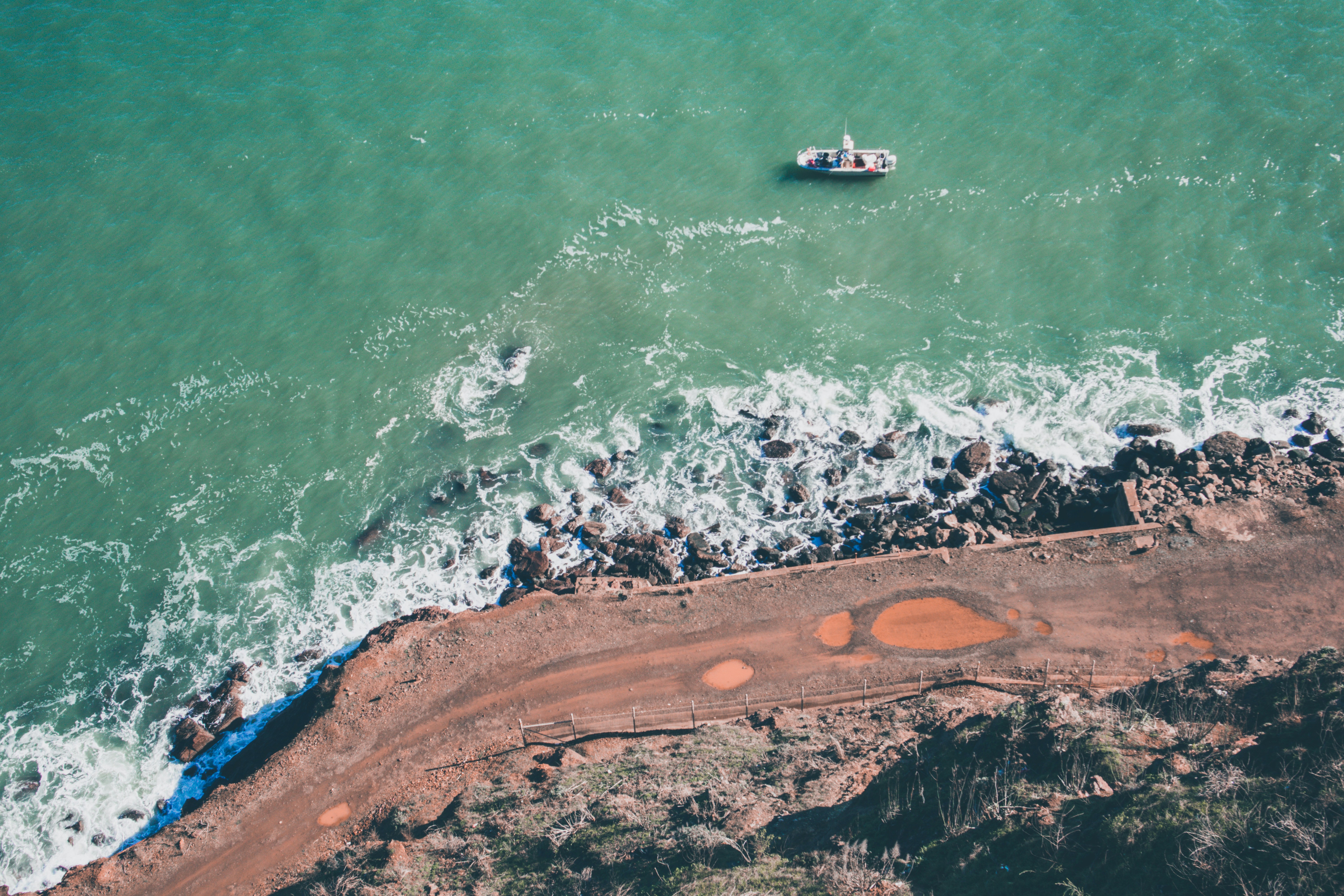 Turquoise Edge: A Lone Boat Traces the Cliffline