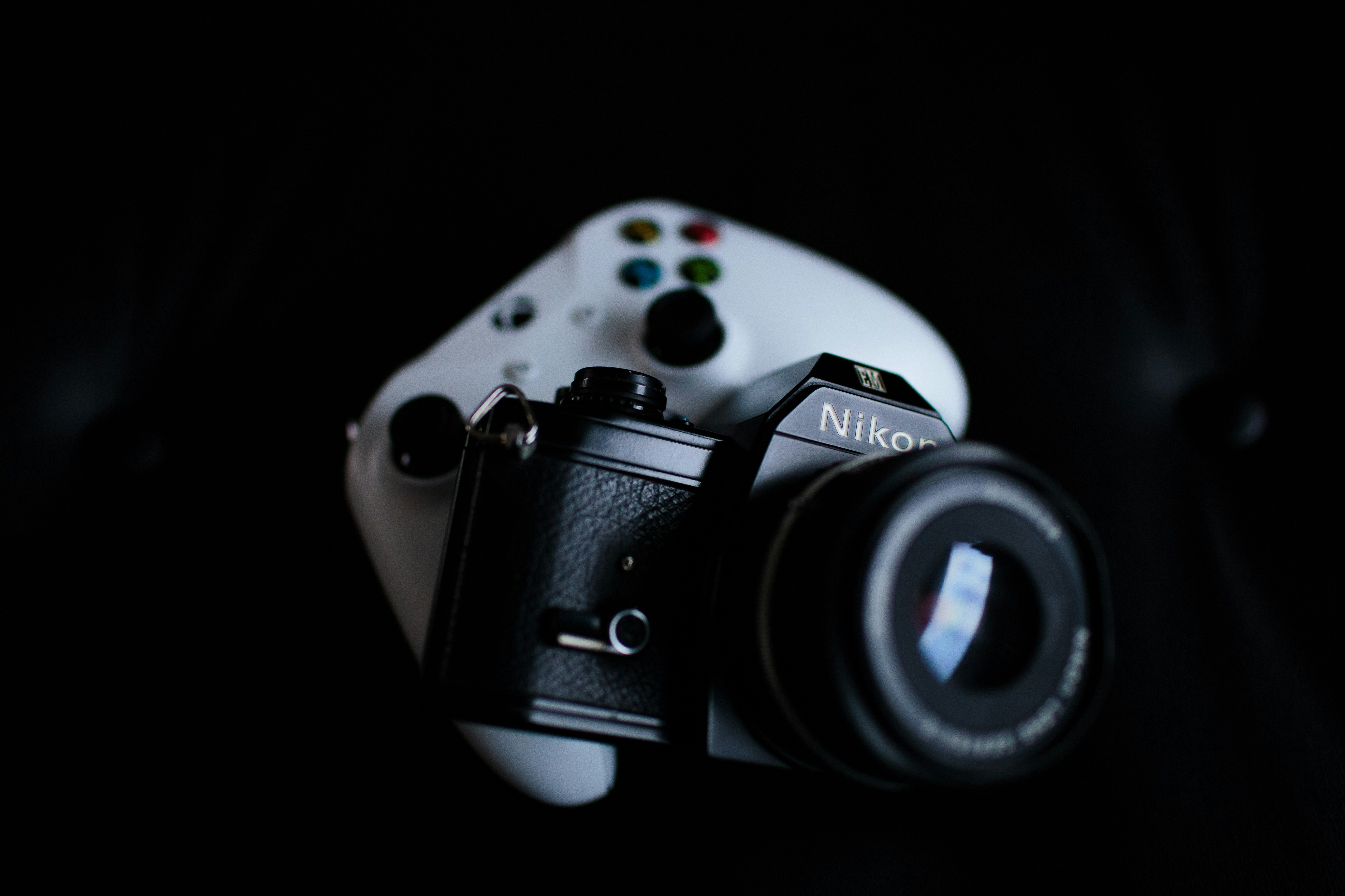 Black Nikon DSLR camera on top of white Xbox One controller photo ...