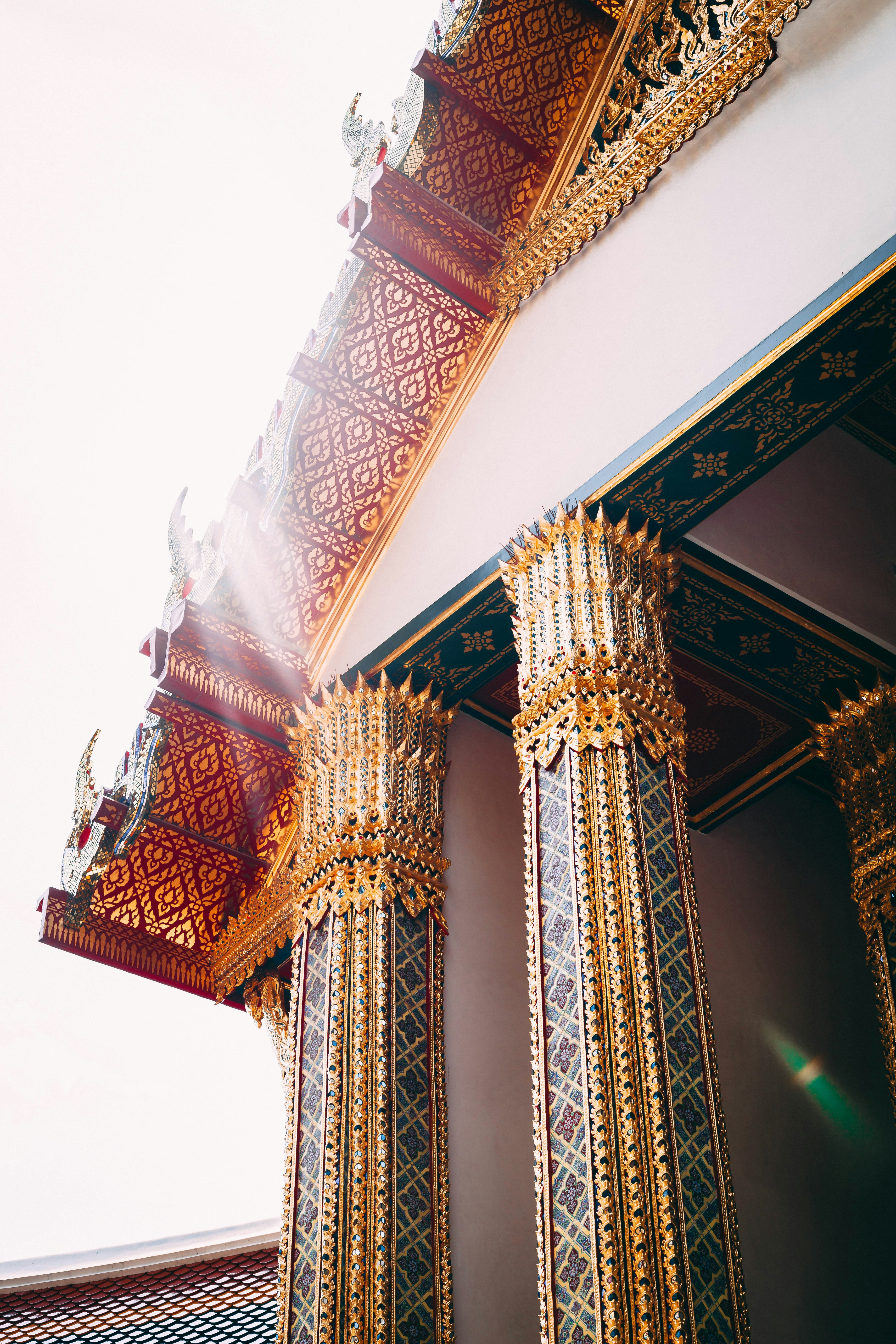Sun-Kissed Gilded Columns Guarding an Ornate Temple Canopy