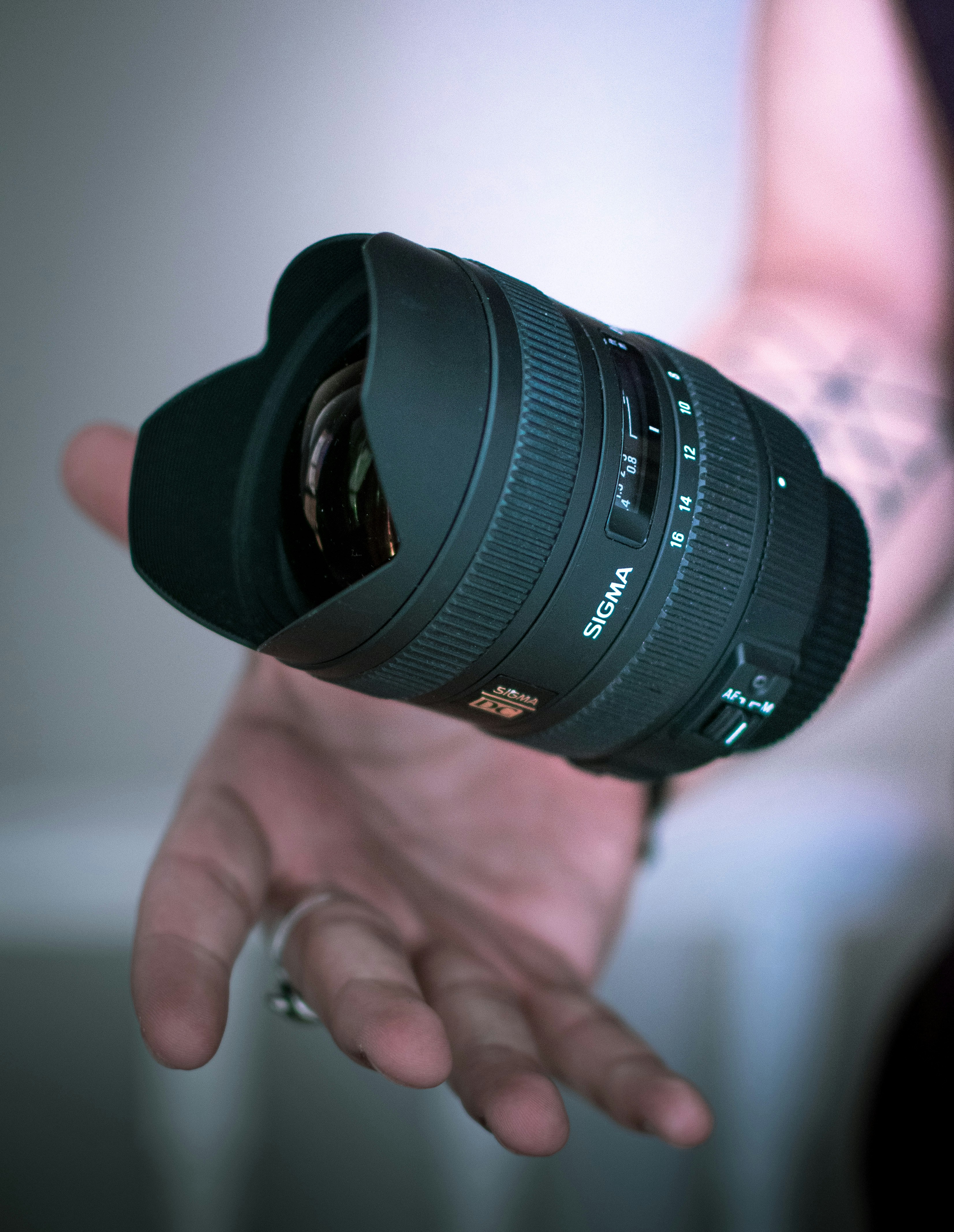 Cradled in Focus: a Sigma lens held close with tactile detail