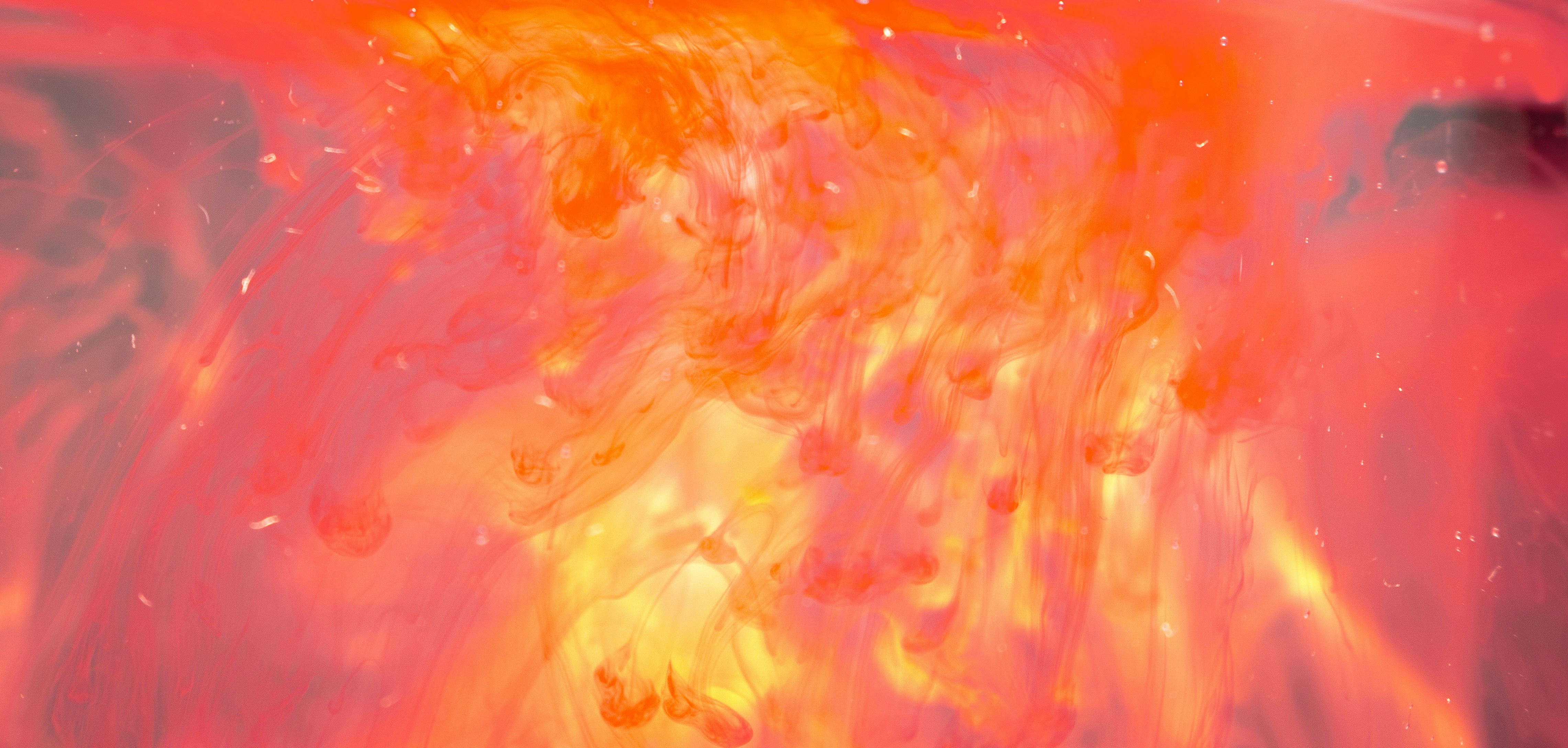 Abstract swirling patterns of orange and red hues, evoking the energy of a volcanic eruption. The vibrant colors blend seamlessly, creating a dynamic visual experience.