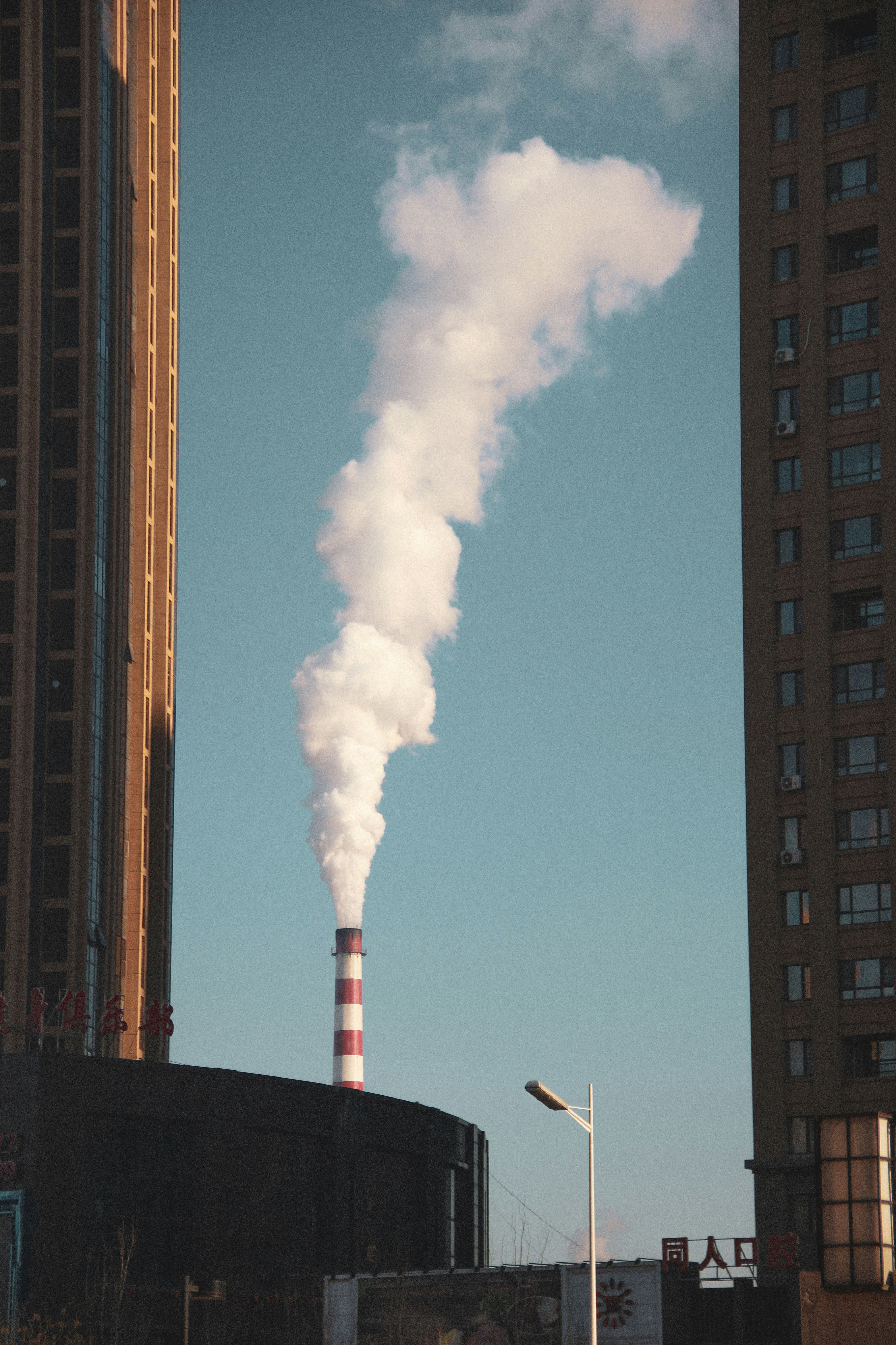 Red-and-white metal pipe blowing white gas on air during daytime photo ...