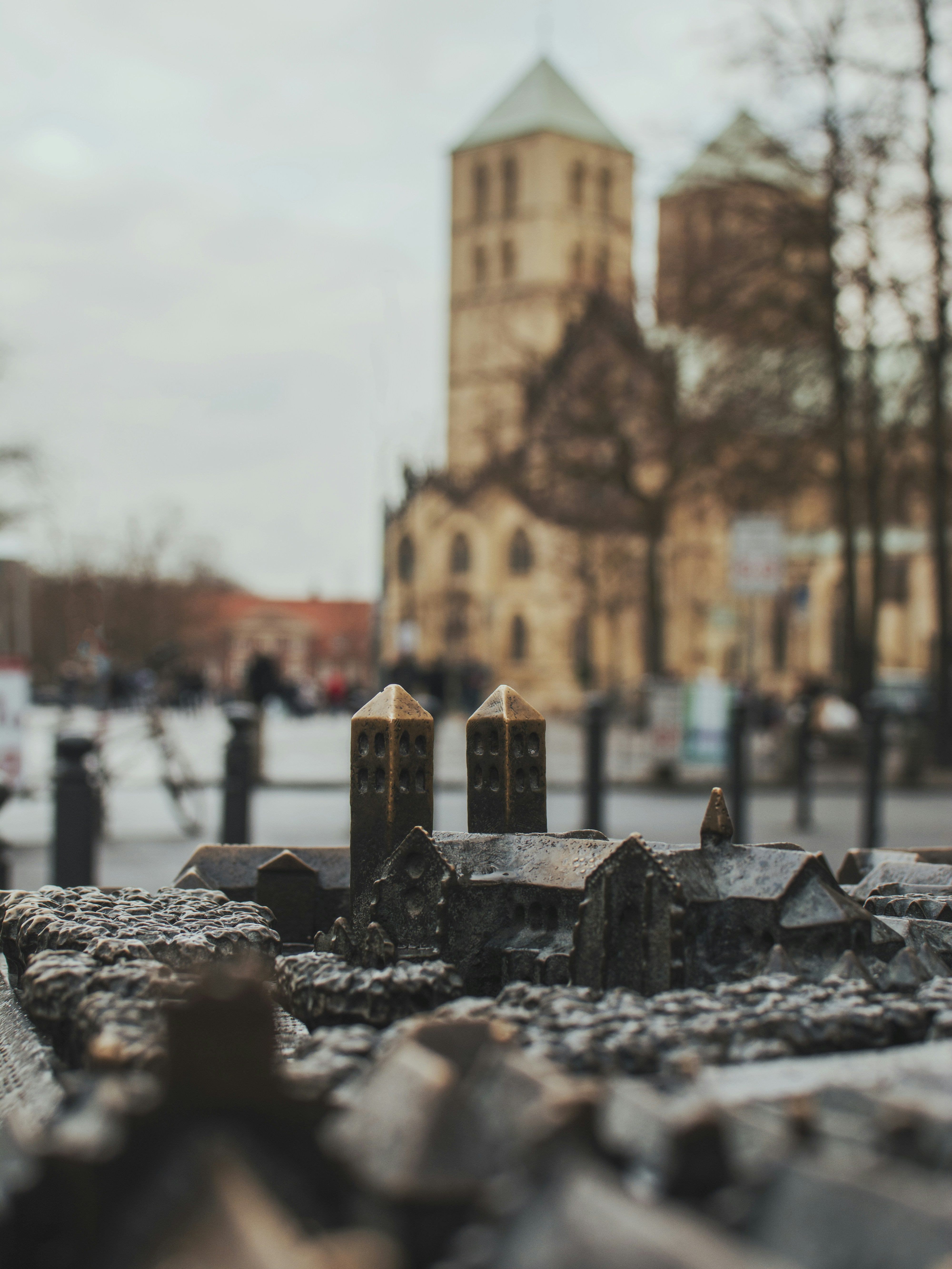 Miniature Citadels in a City Square, Framed by a Blurred Cathedral