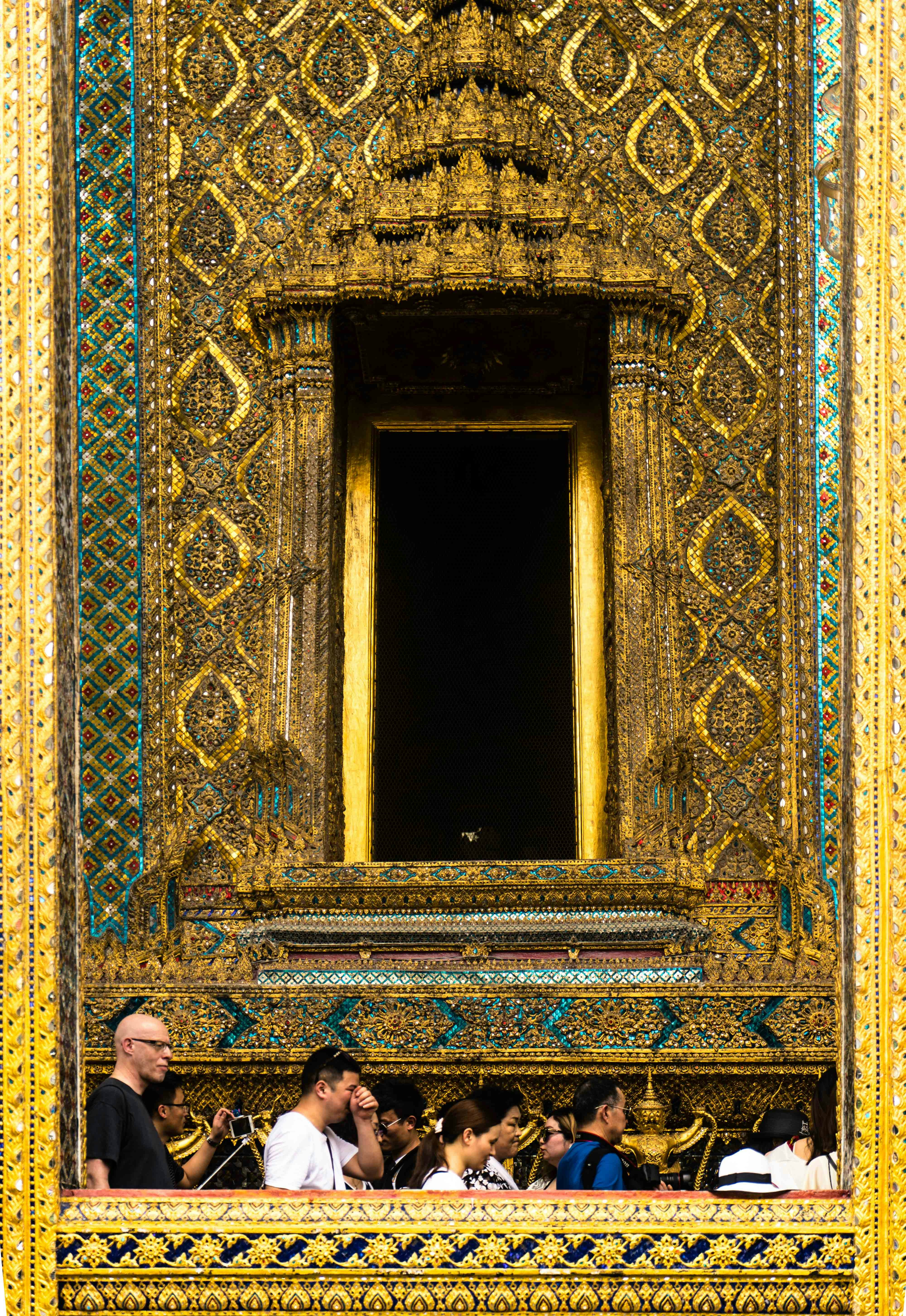 Golden Thresholds: Tourists Beneath a Lattice-Patterned Temple Facade