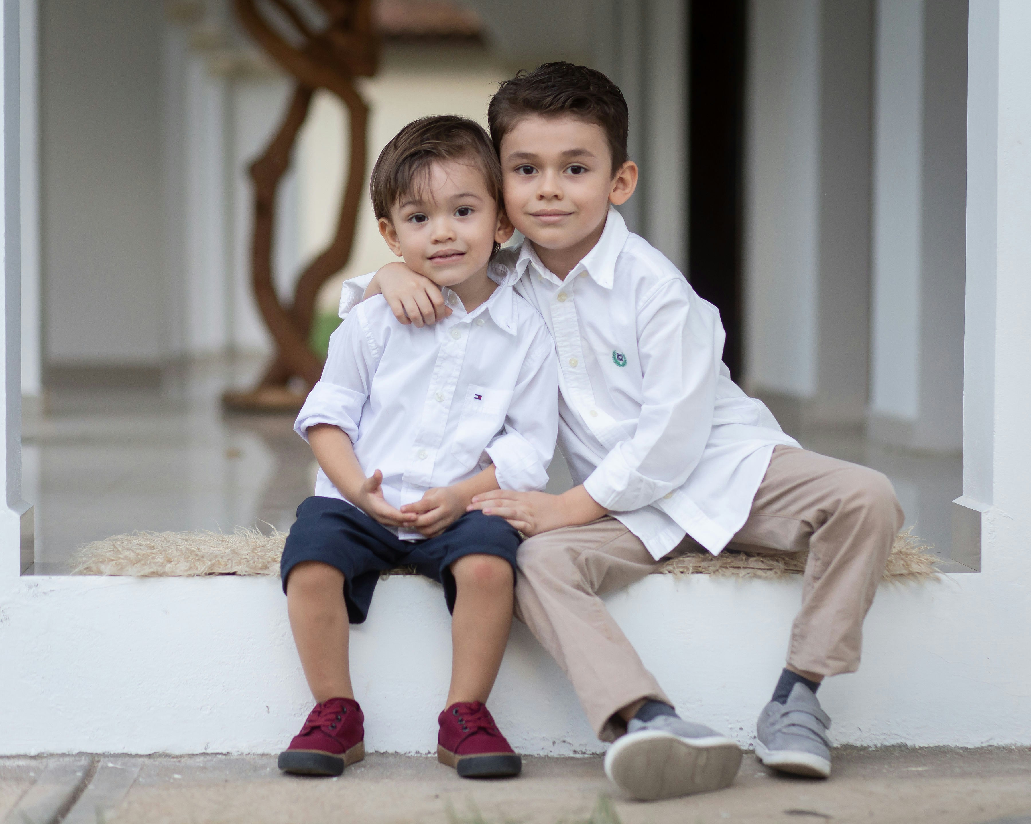 Two Brothers in White: Quiet Bond on a Sunlit Step