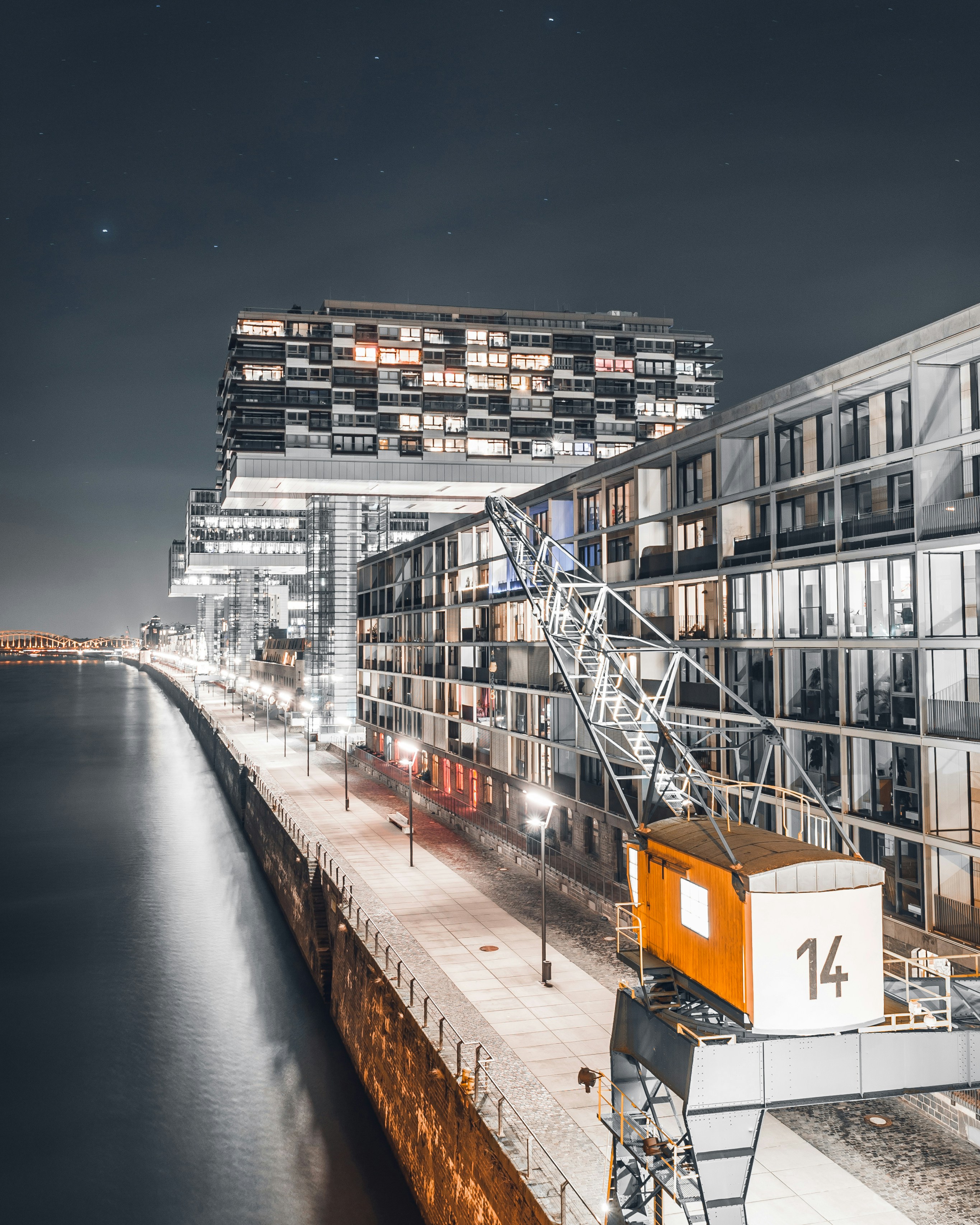Gray glass building beside body of water during night time photo – Free ...
