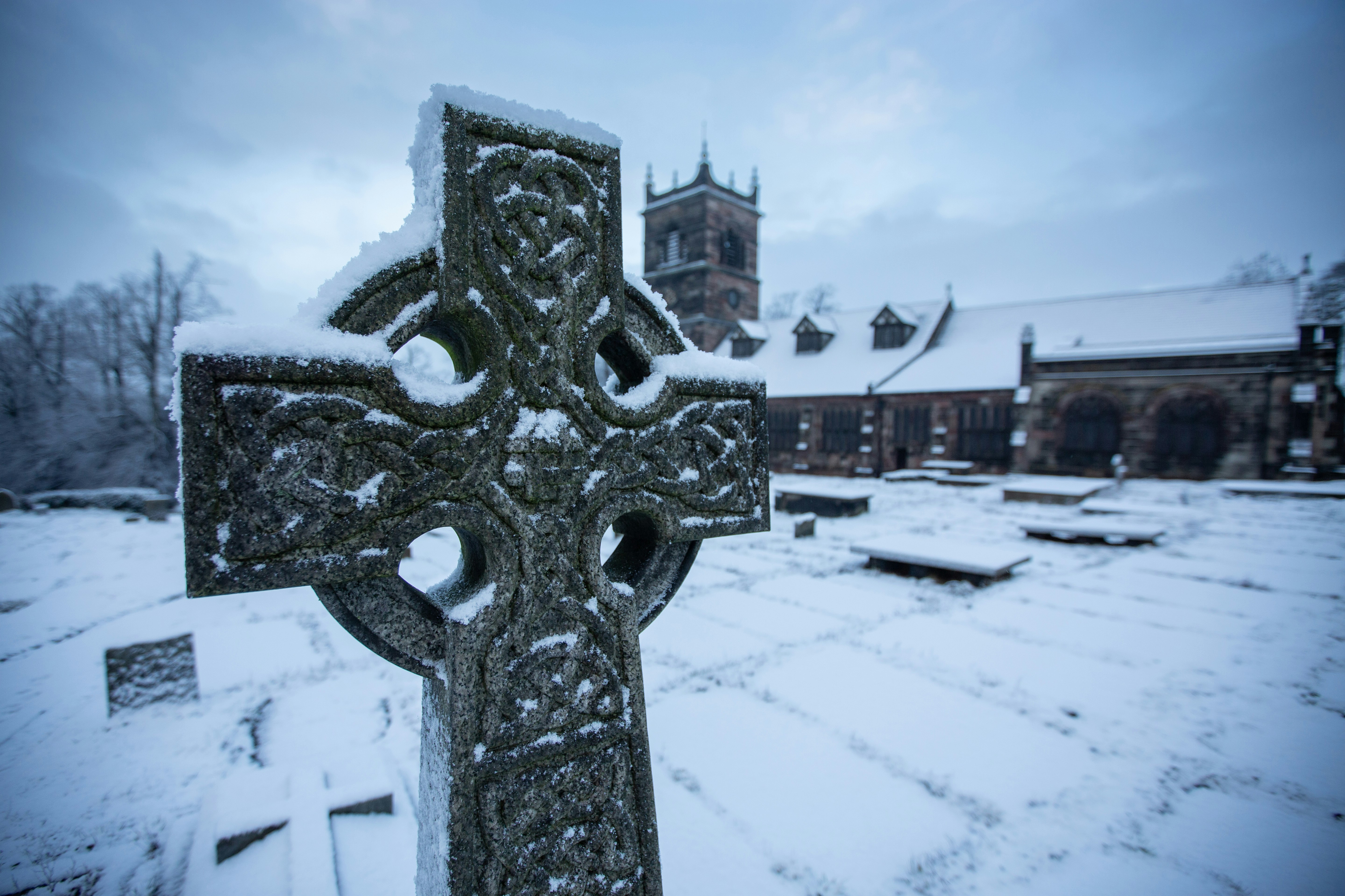 Frost-etched Celtic Cross in a Snow-Draped Churchyard