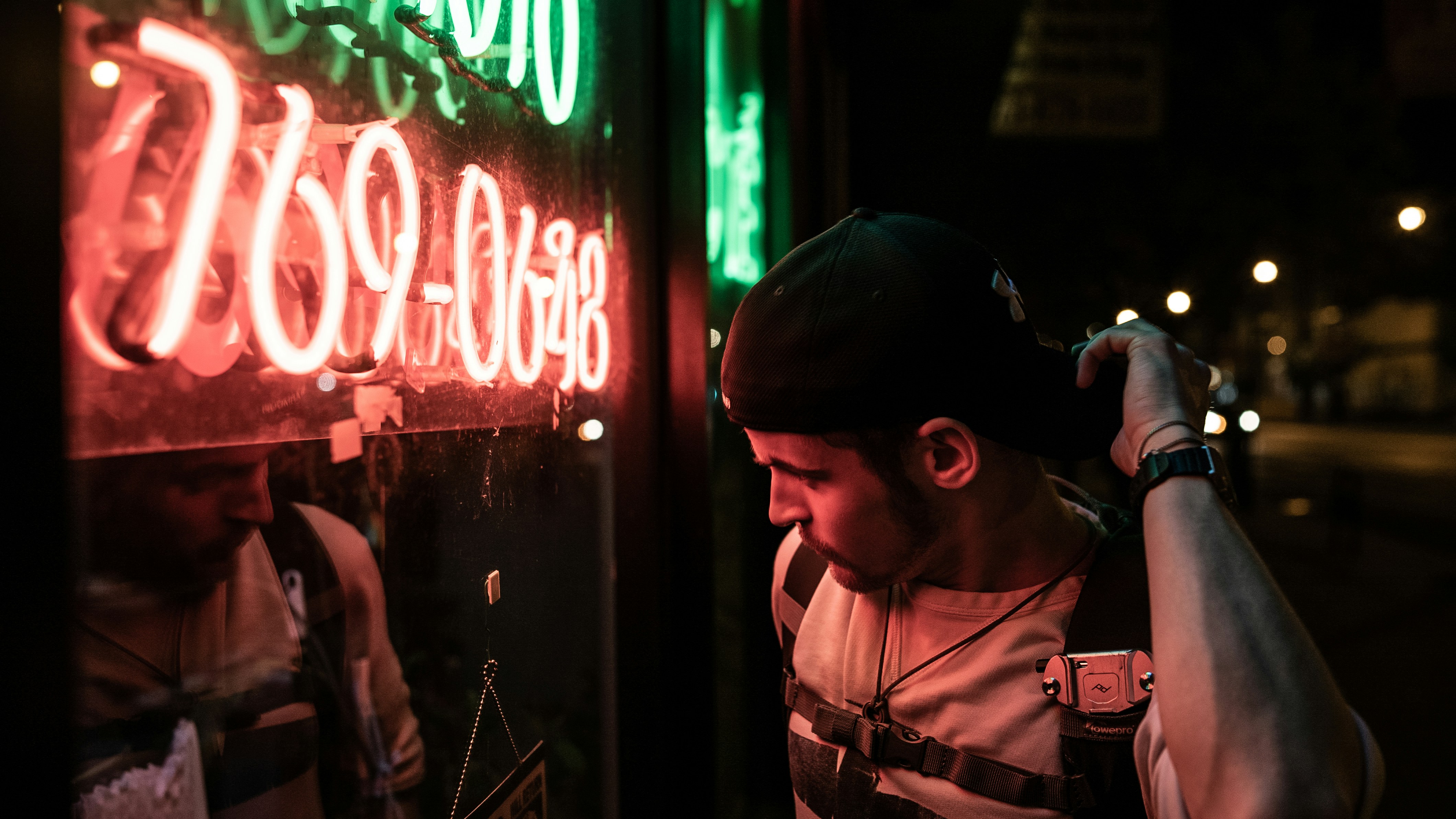 Neon Gaze in a Quiet Street: Portrait Beneath Red-Green Night Signs