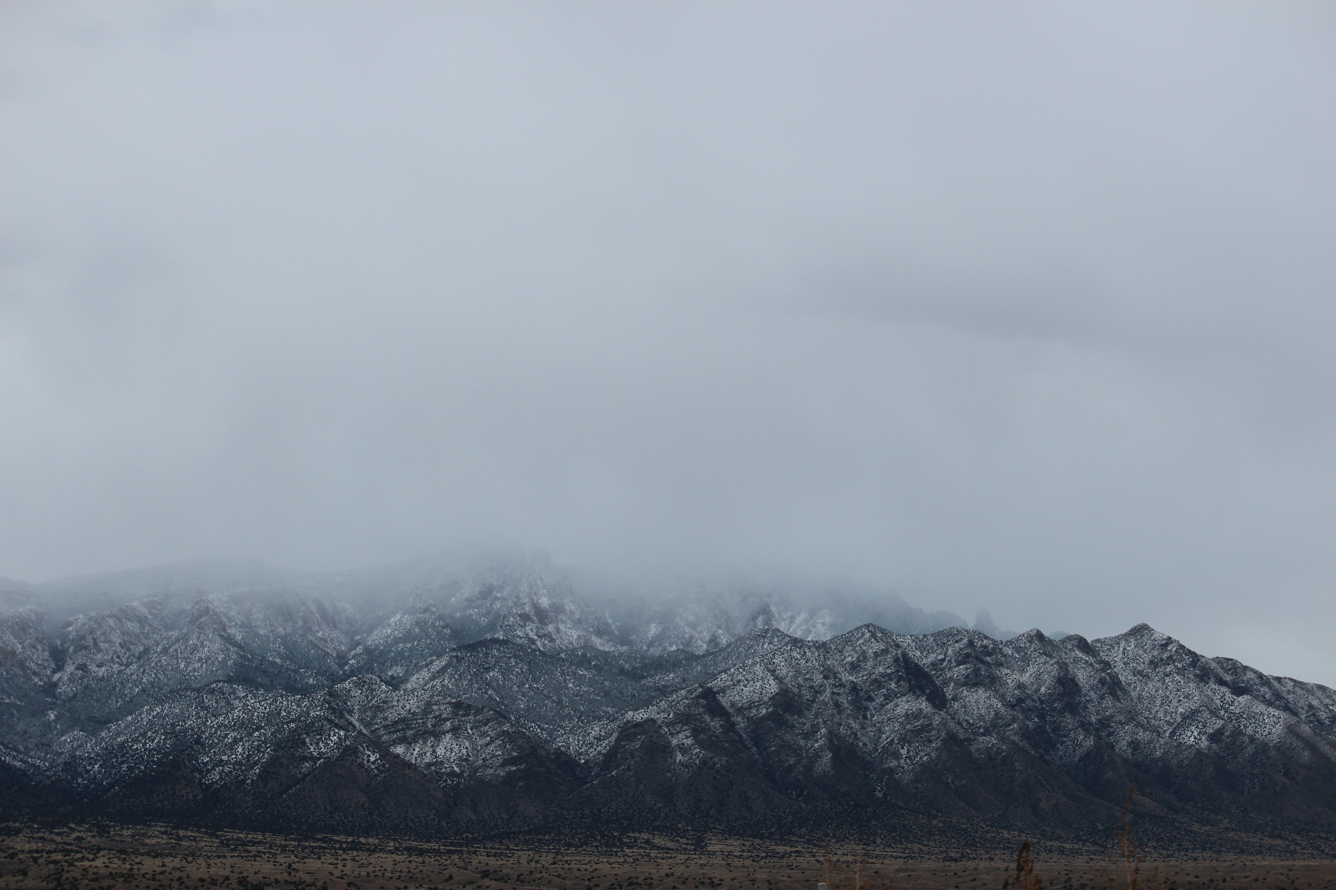 Snow-kissed Ridge Beneath a Cloud-Choked Sky