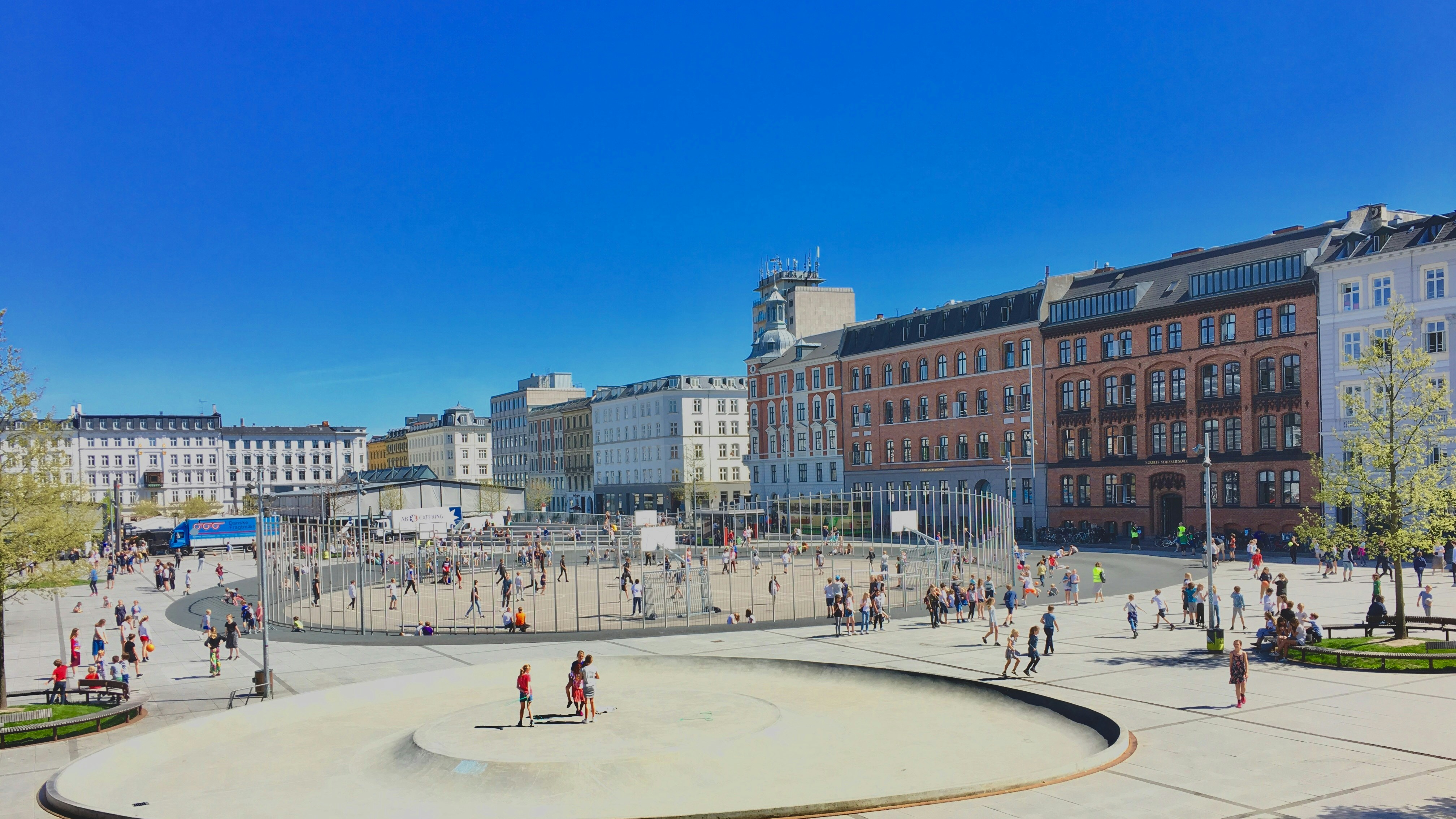 Centre Plaza Pulse: People Gathered Around a Circular Basin in a Historic European Square