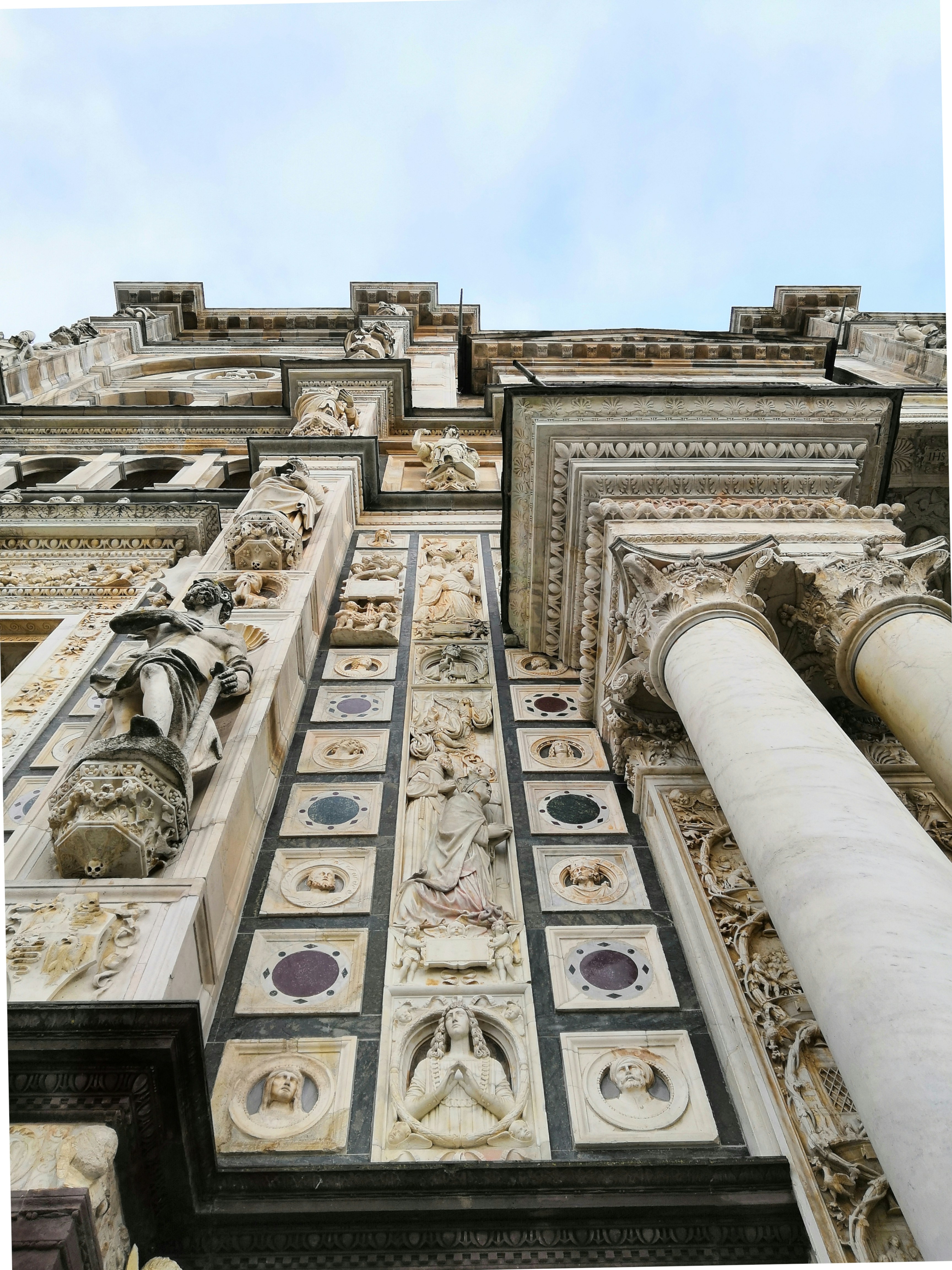 Ornate architectural facade with detailed carvings and towering columns under a clear sky.