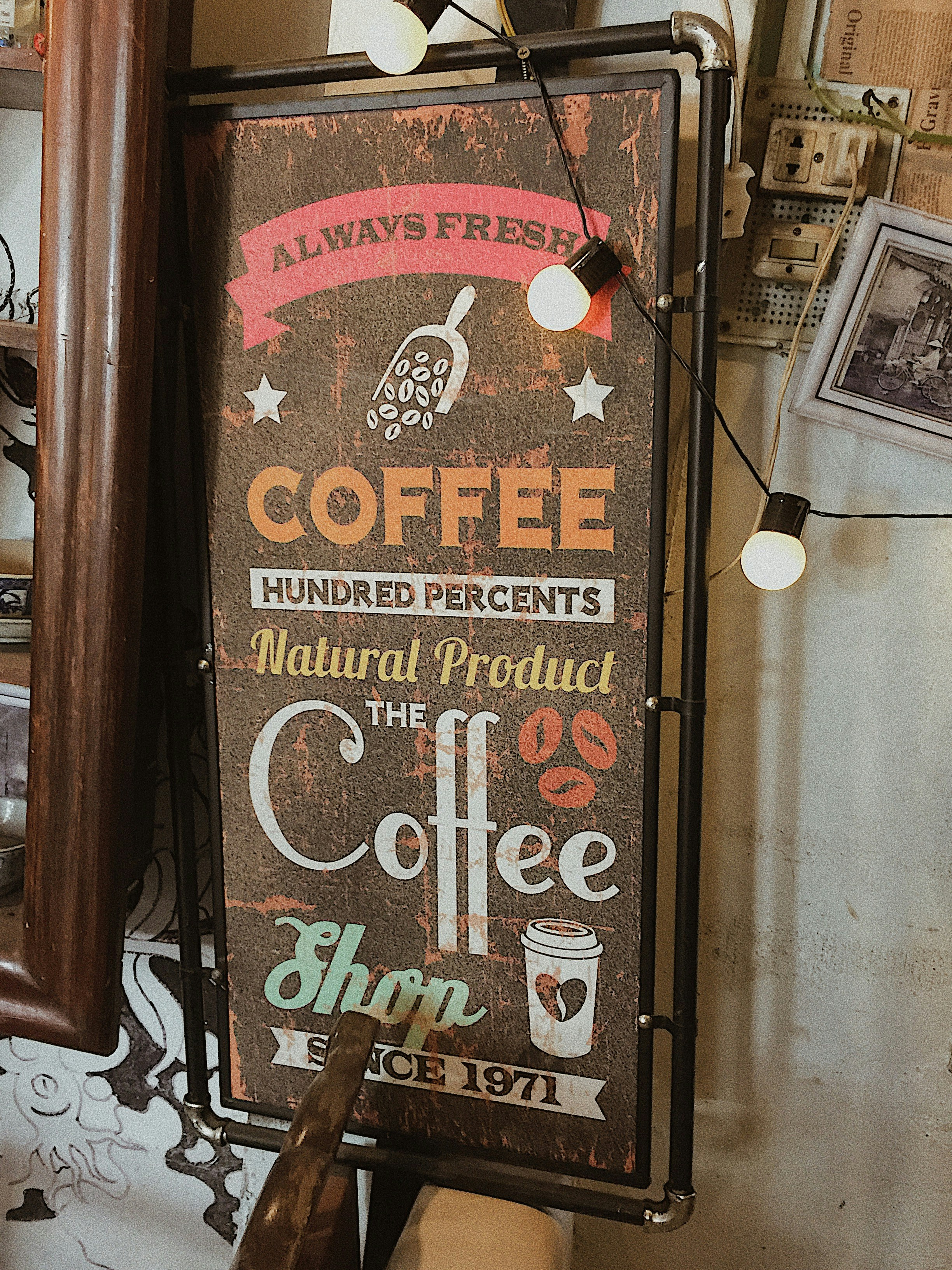 Colorful vintage sign promoting a coffee shop, highlighting its natural products and history since 1971.