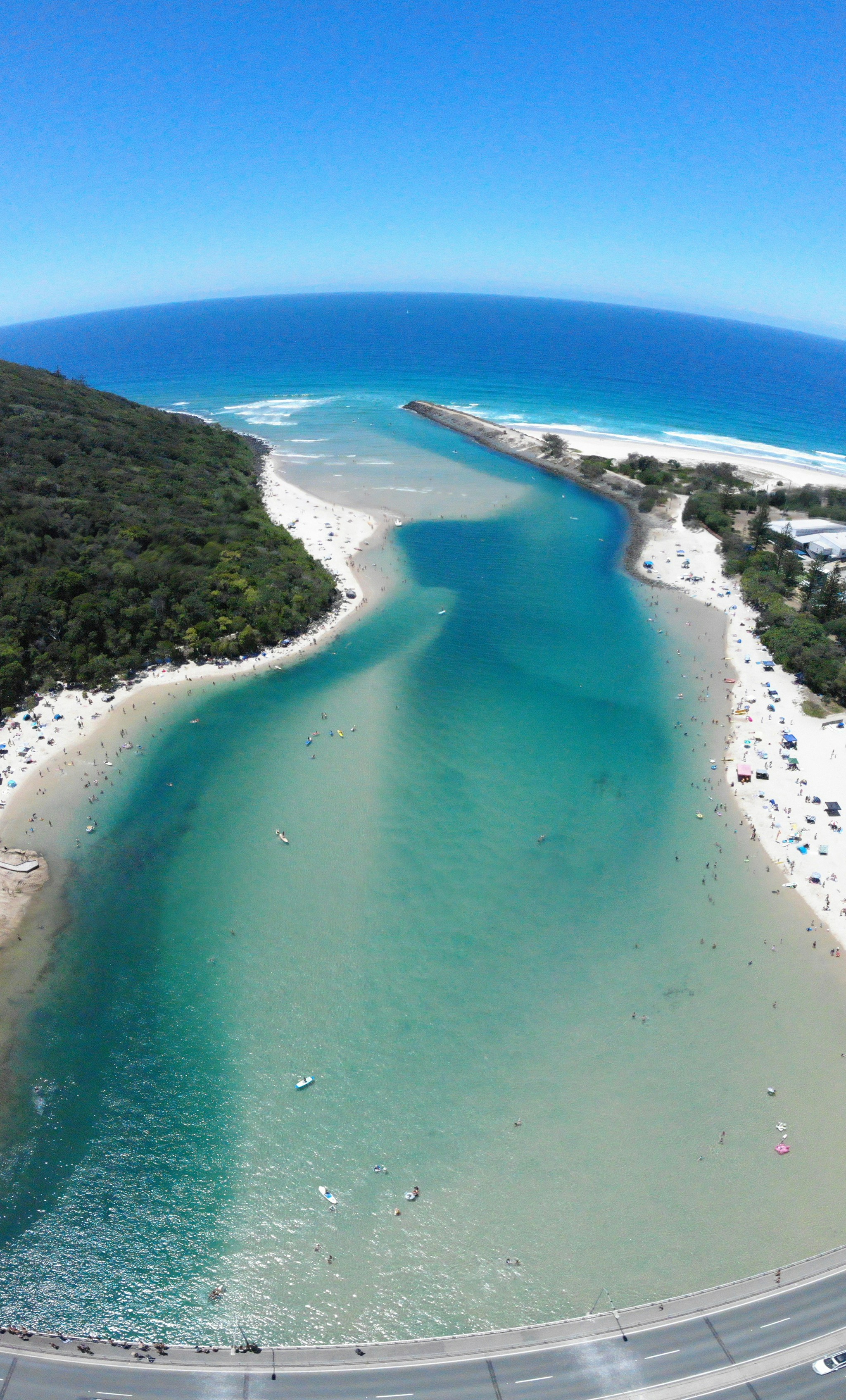 Ribbon of Turquoise: Aerial Portrait of a Coastal Inlet Between Beachfront and Breakwater