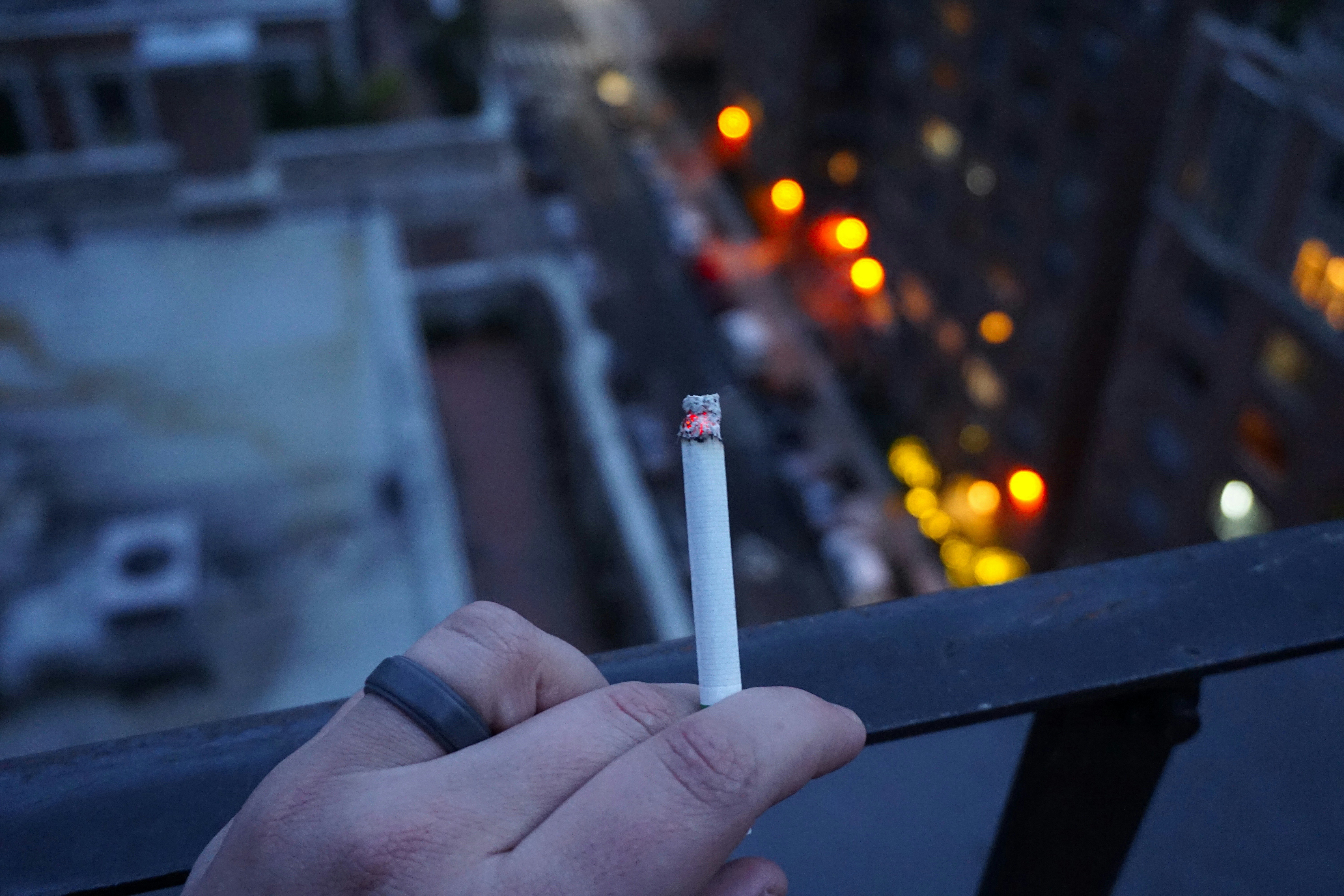 Blue Hour Ash on a Rooftop Balcony as Neon Bokeh Dances Below