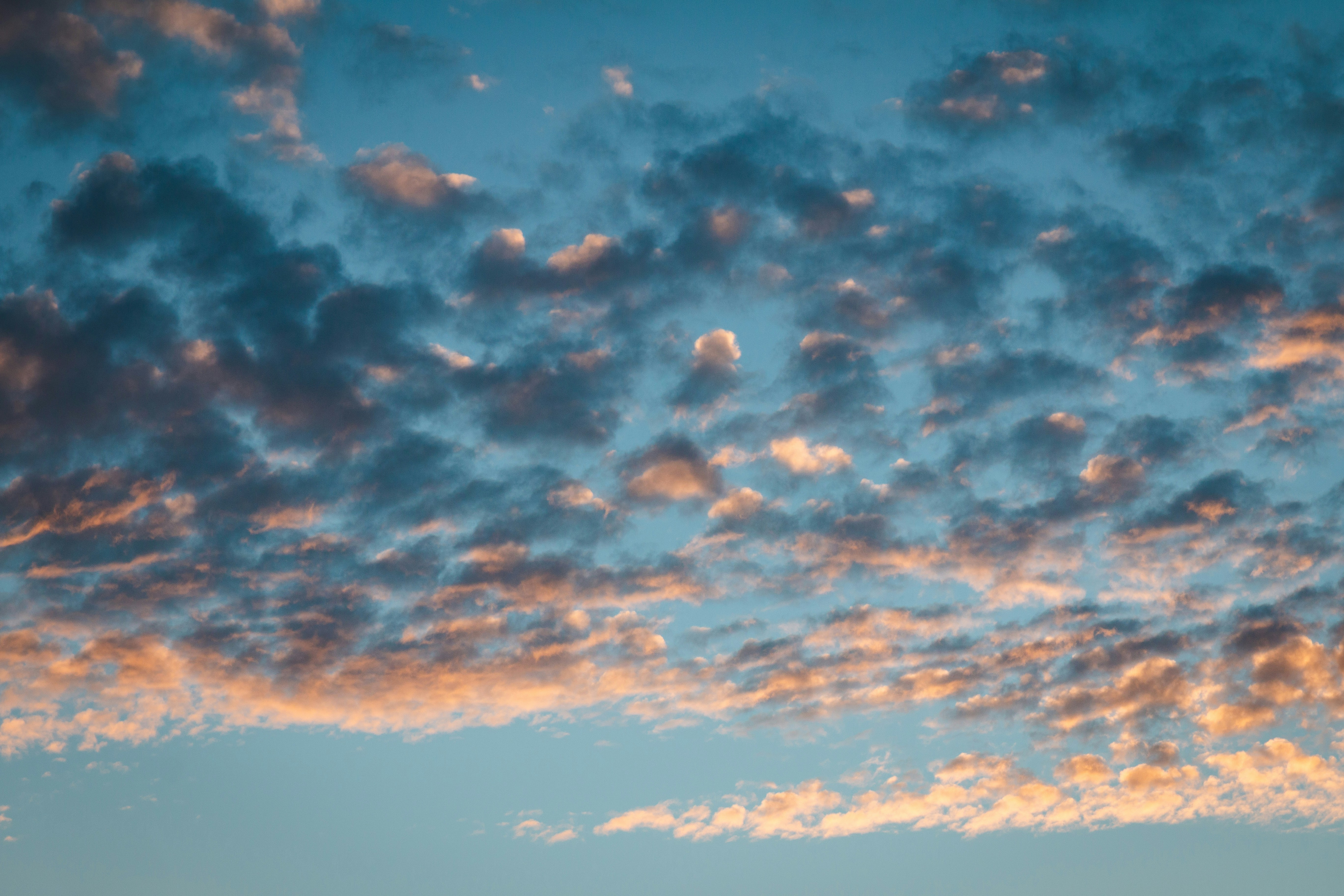 A vibrant display of clouds painted in hues of blue and orange during sunset, creating a dynamic atmosphere.