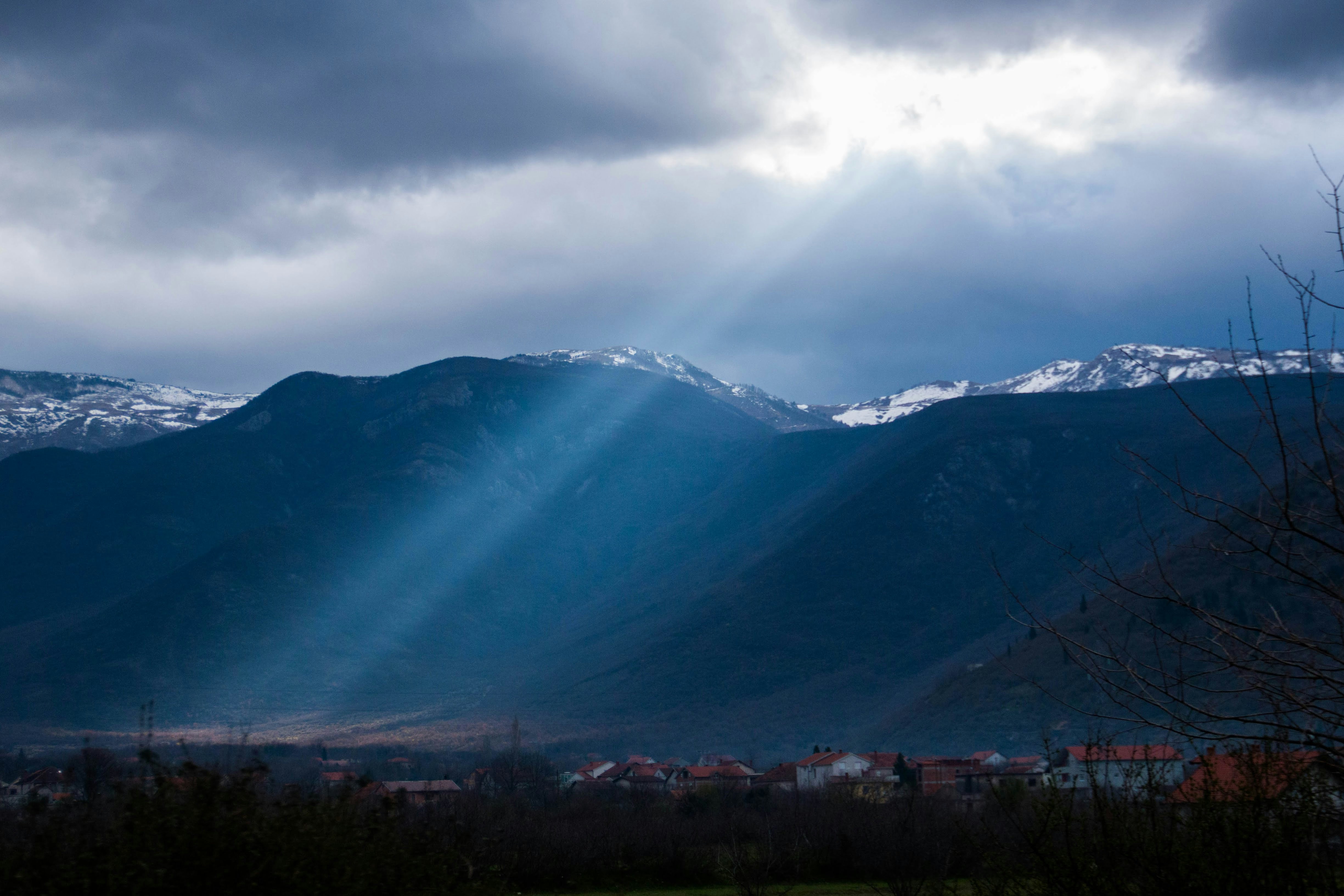 Rays Carve a Quiet Valley Beneath Snow-Kissed Ridges