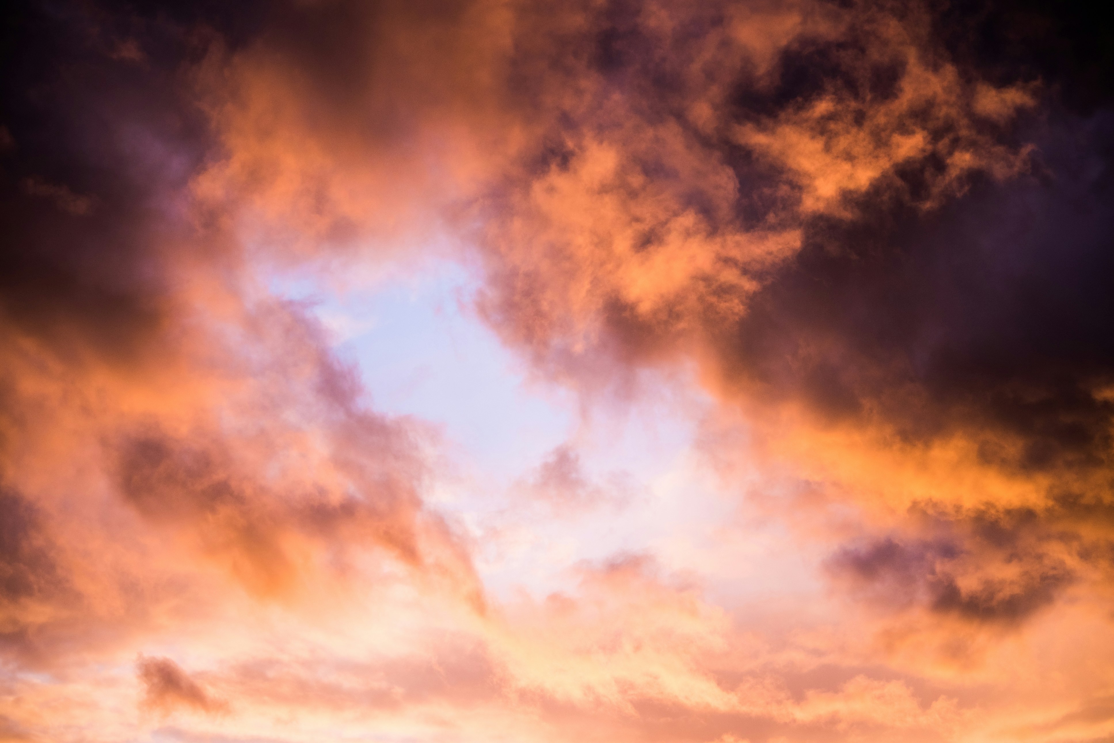 Vibrant clouds illuminated by the setting sun, showcasing a gradient of warm colors against a backdrop of twilight.