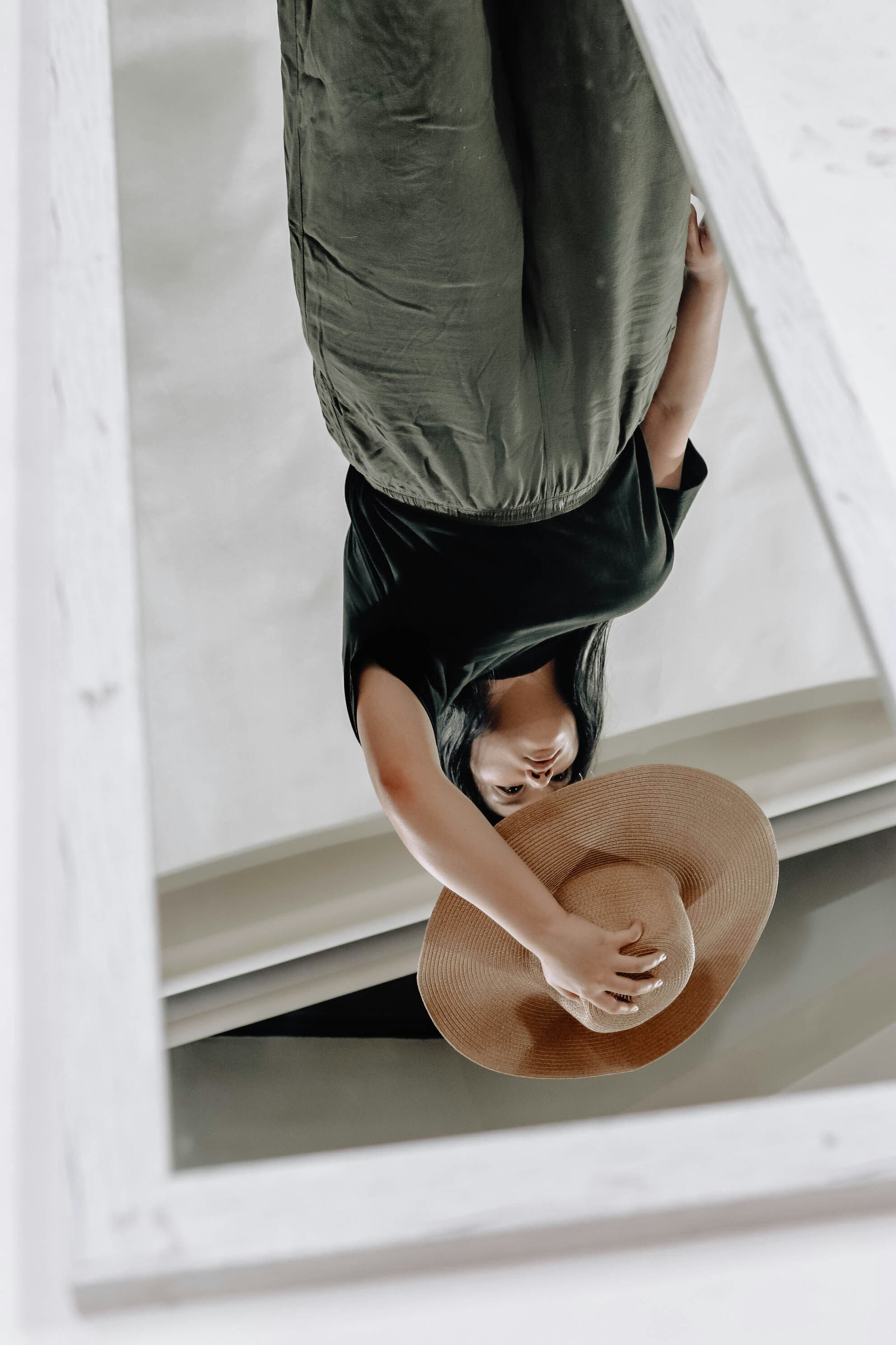 Upside-Down Grace: Hat in Hand Within a White-Frame Portrait