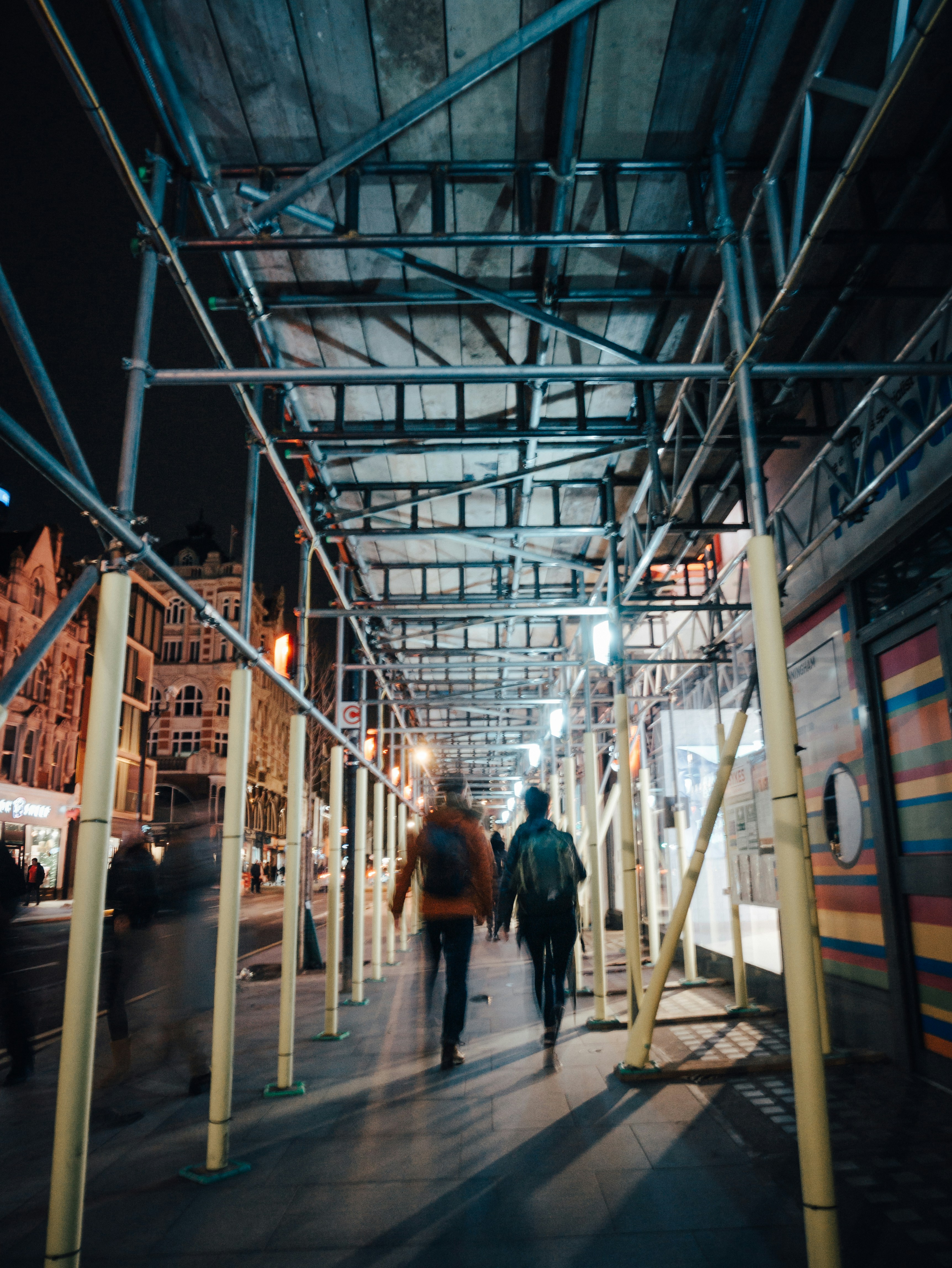 Under Neon Scaffolds: Night Walk Through Moving Shadows