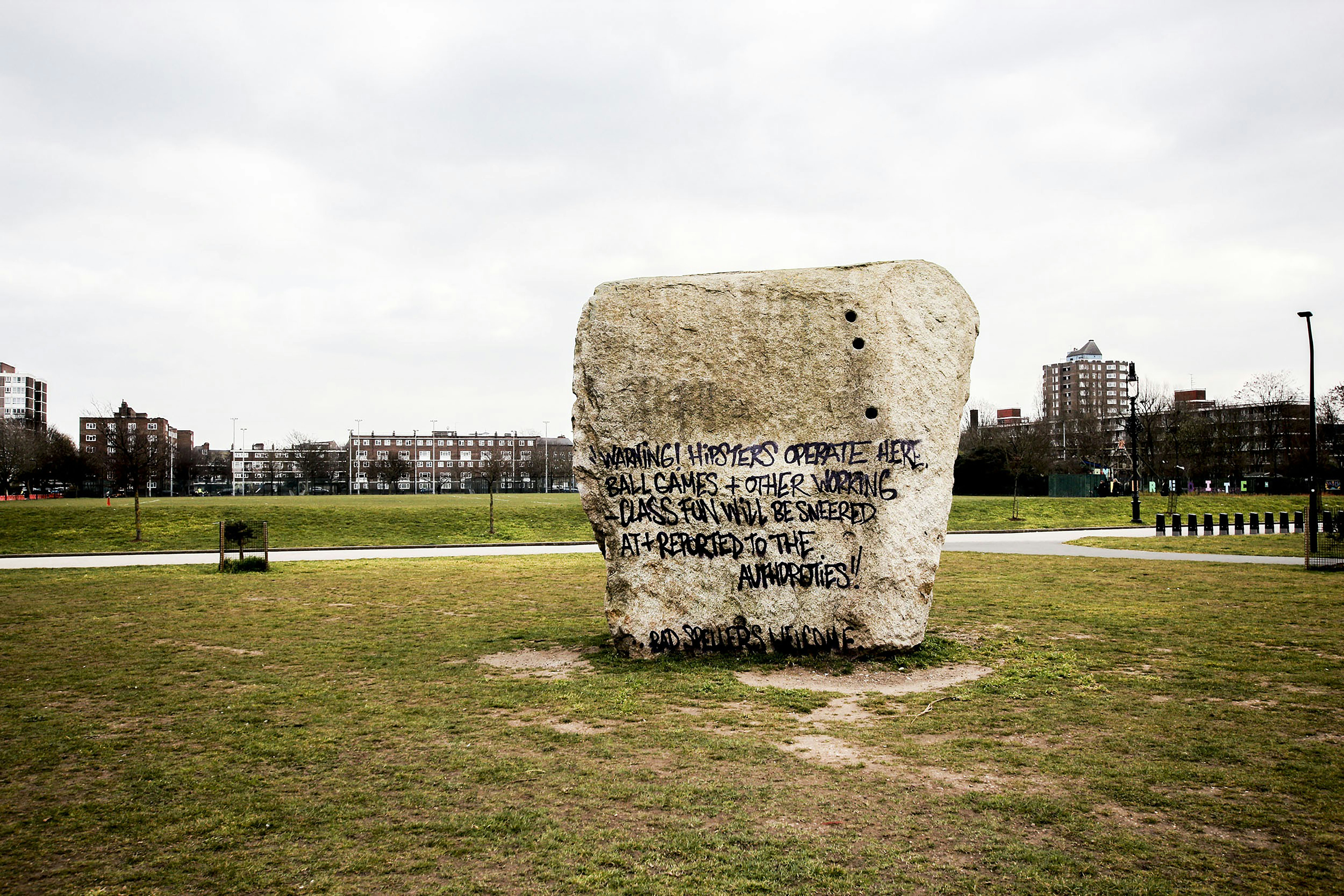 Graffitied Stone Monolith in a Quiet Park