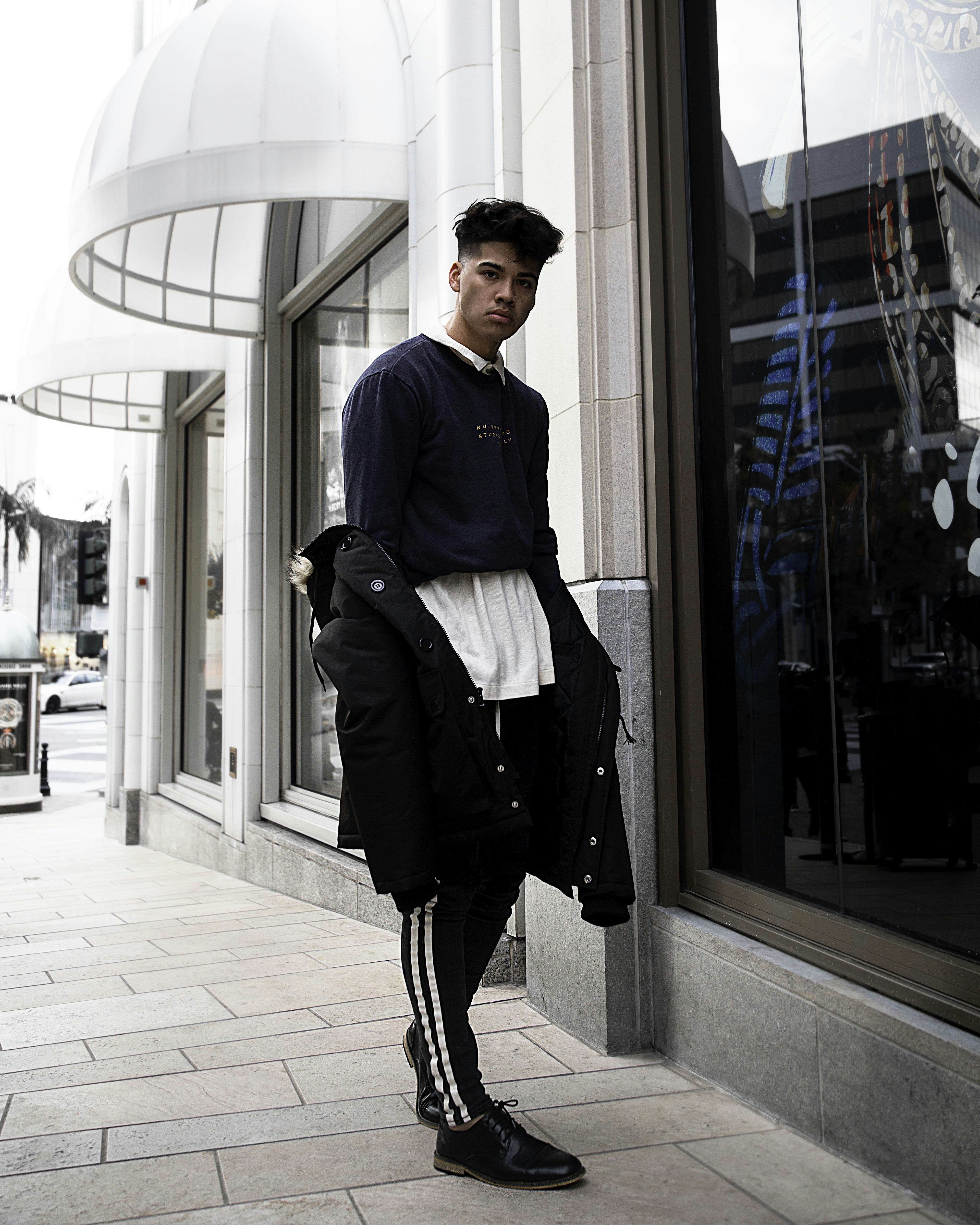 Man removing his jacket in from of store glass display photo – Free ...
