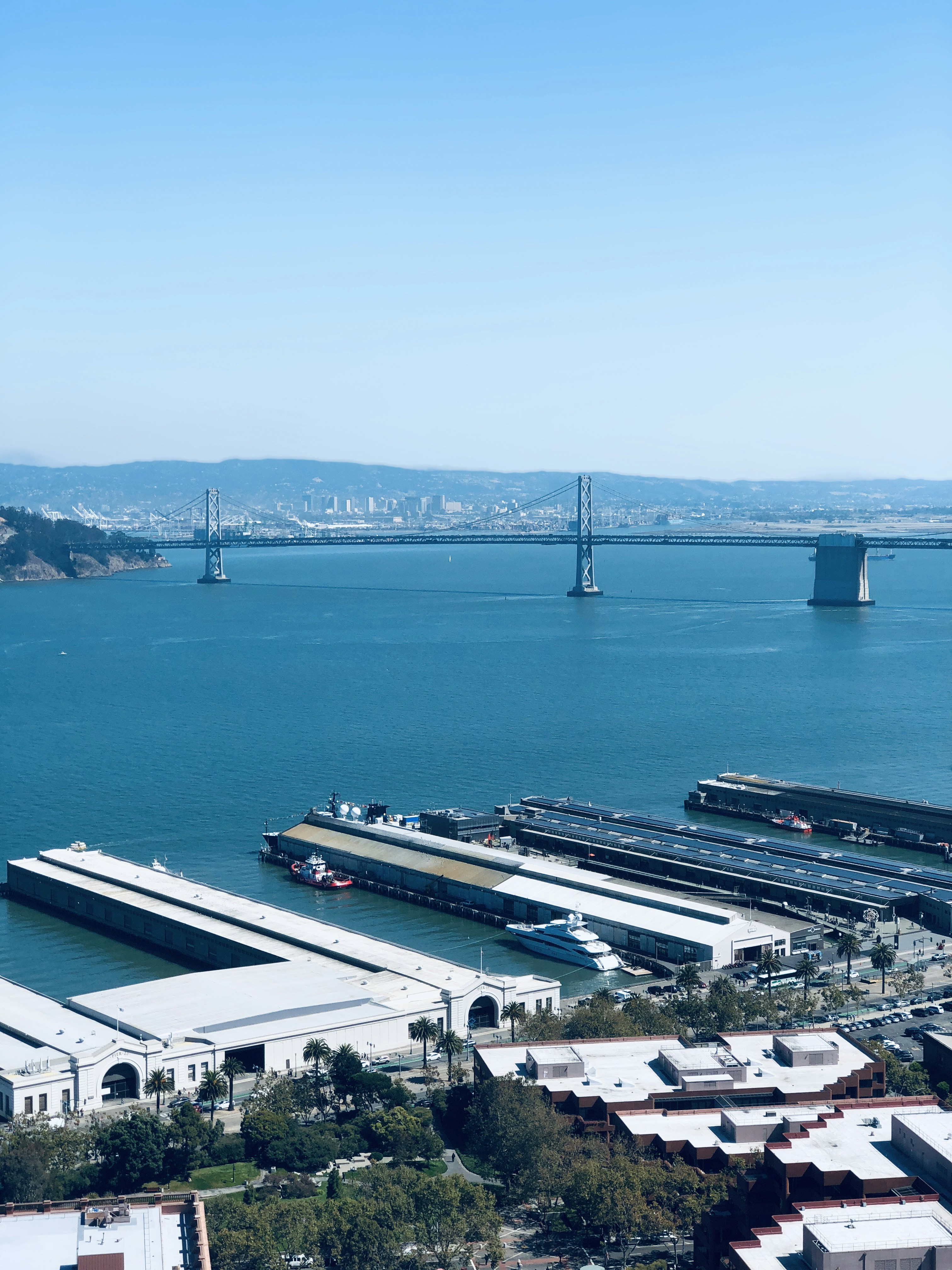 Aerial view of the blue bay and bridge with port facilities below