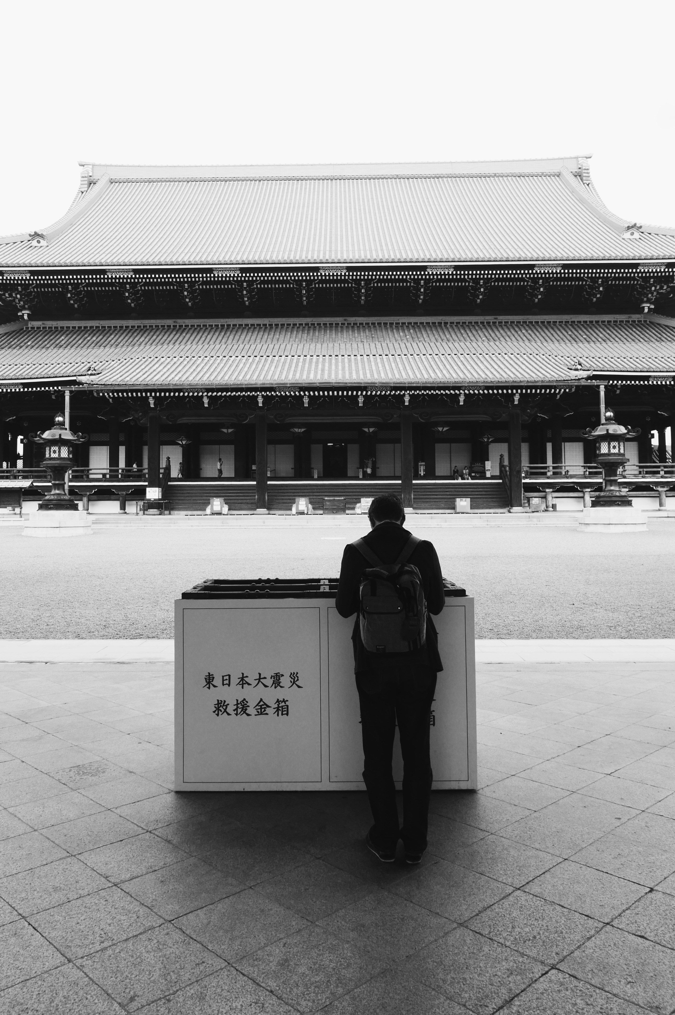 Traveler in Shadow at the Threshold of a Grand Japanese Temple