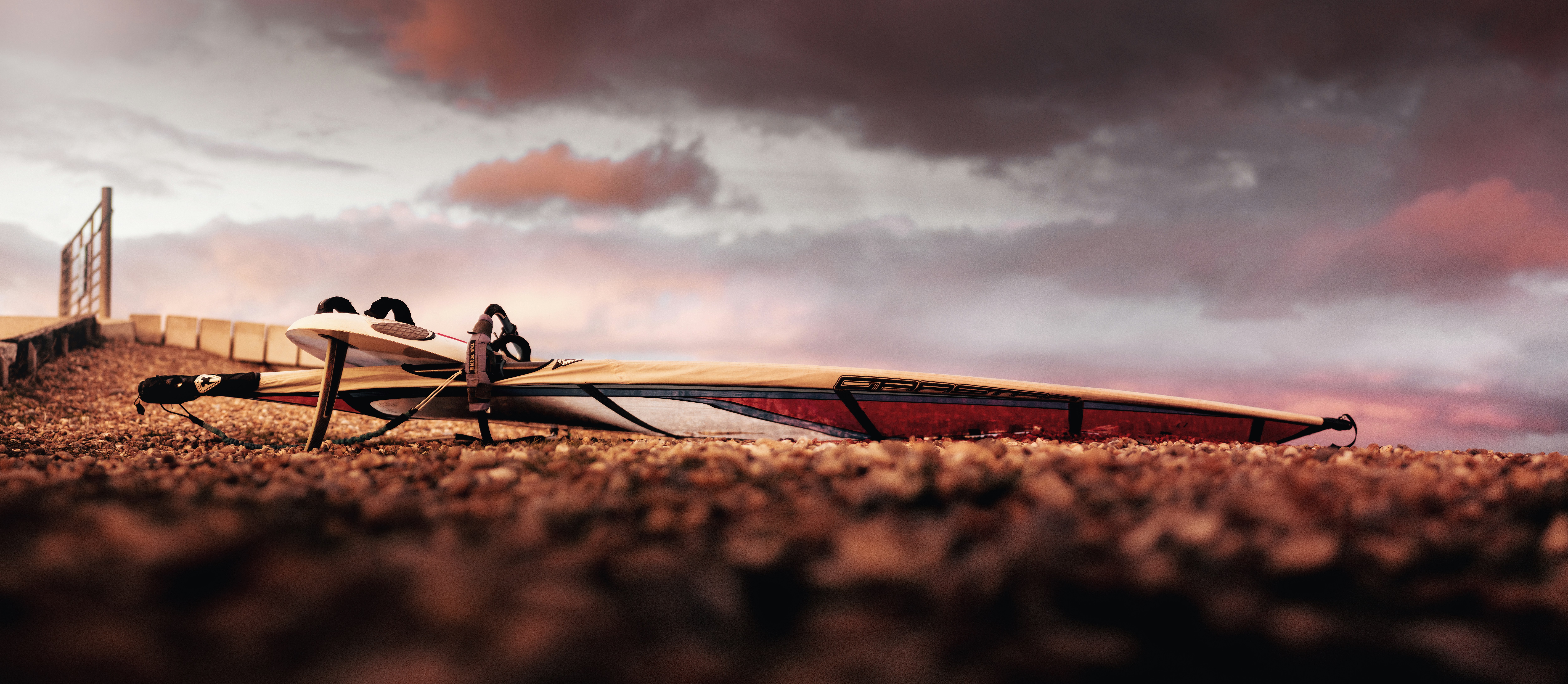 Low Tide, High Lines: A Quiet Shoreline with a Surfboard at Dusk