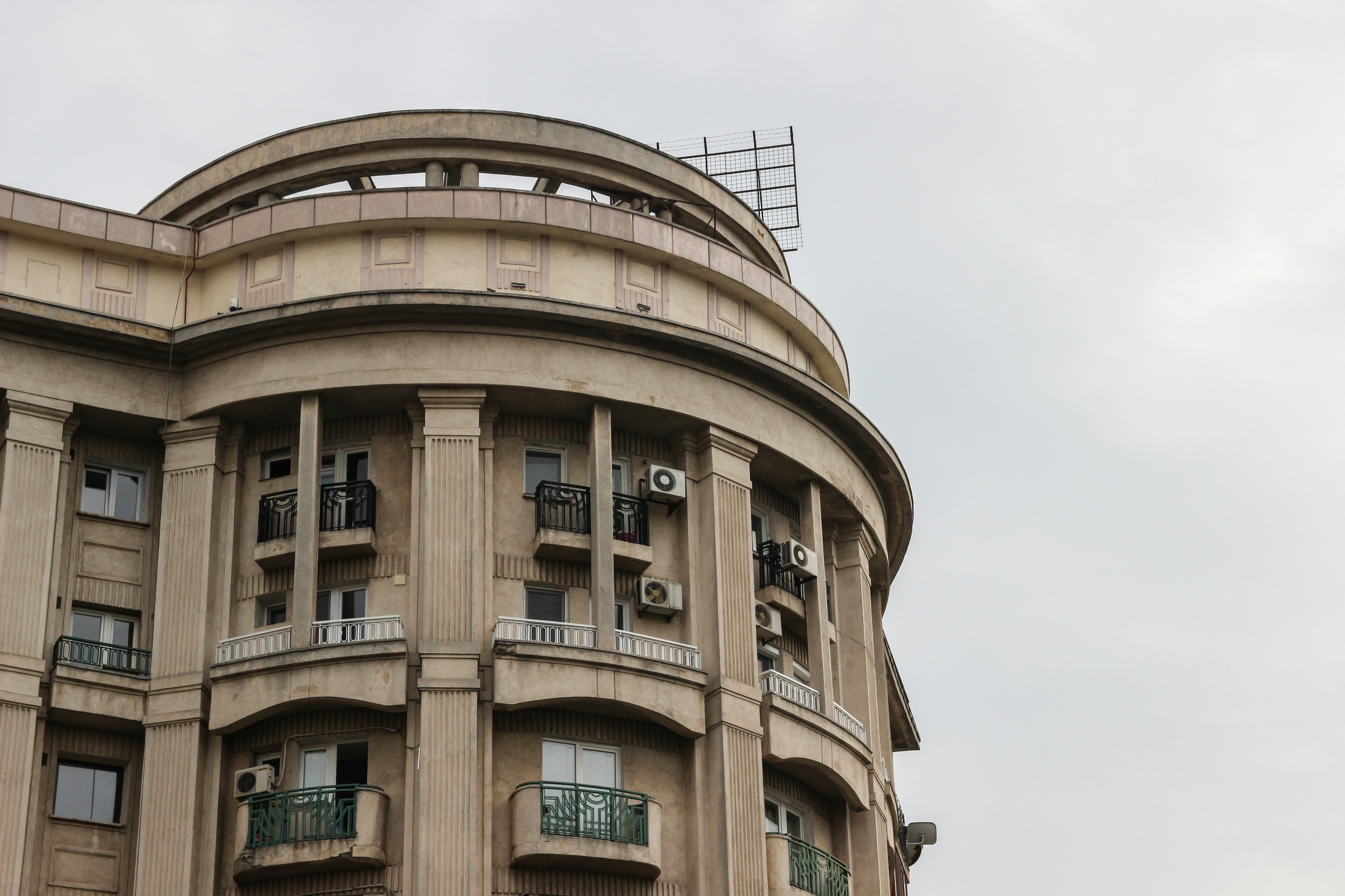Rounded Corner Tower: Beiges and Balconies Under an Overcast Sky