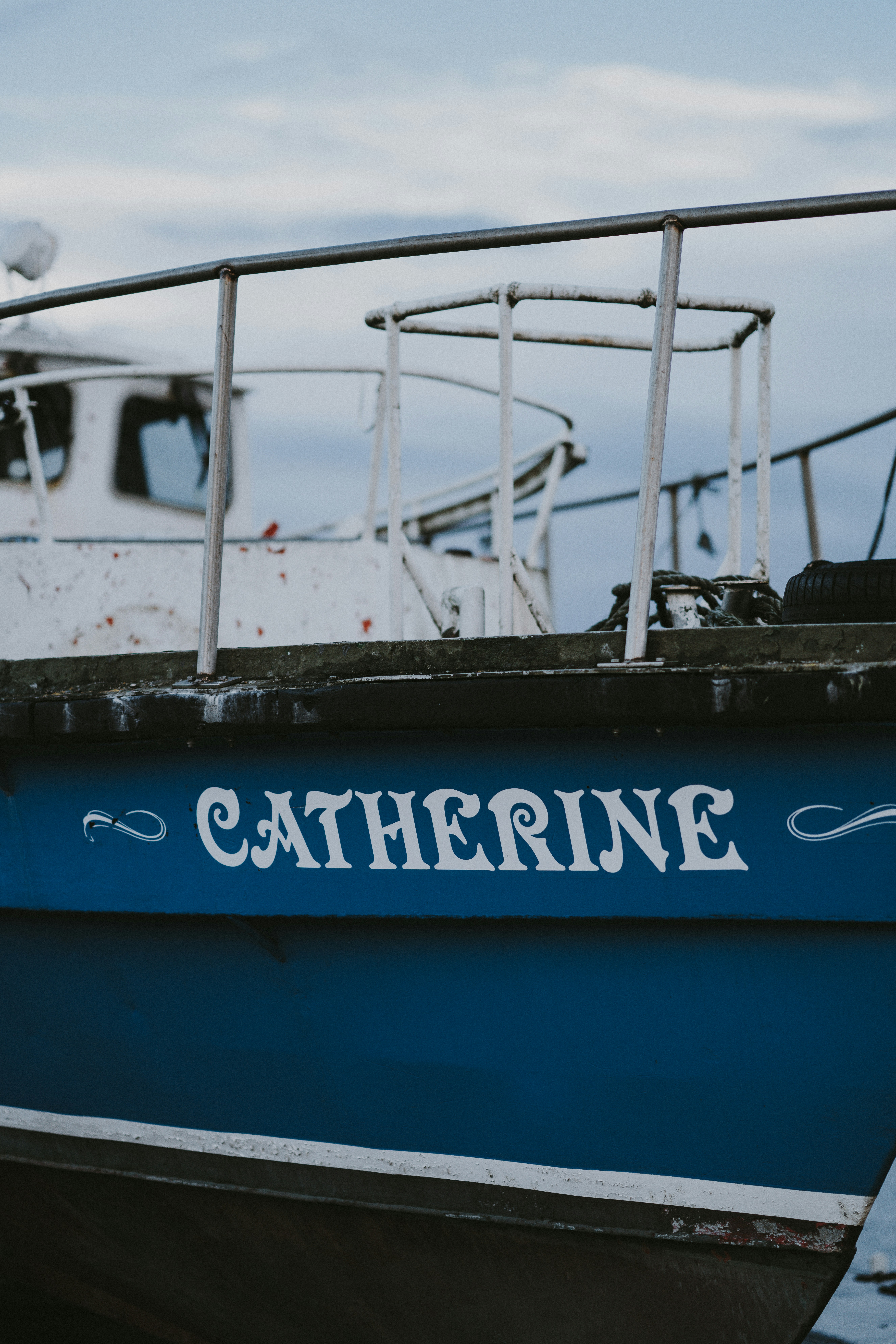 Catherine's Blue Hull: A Weathered Boat Named in White Script