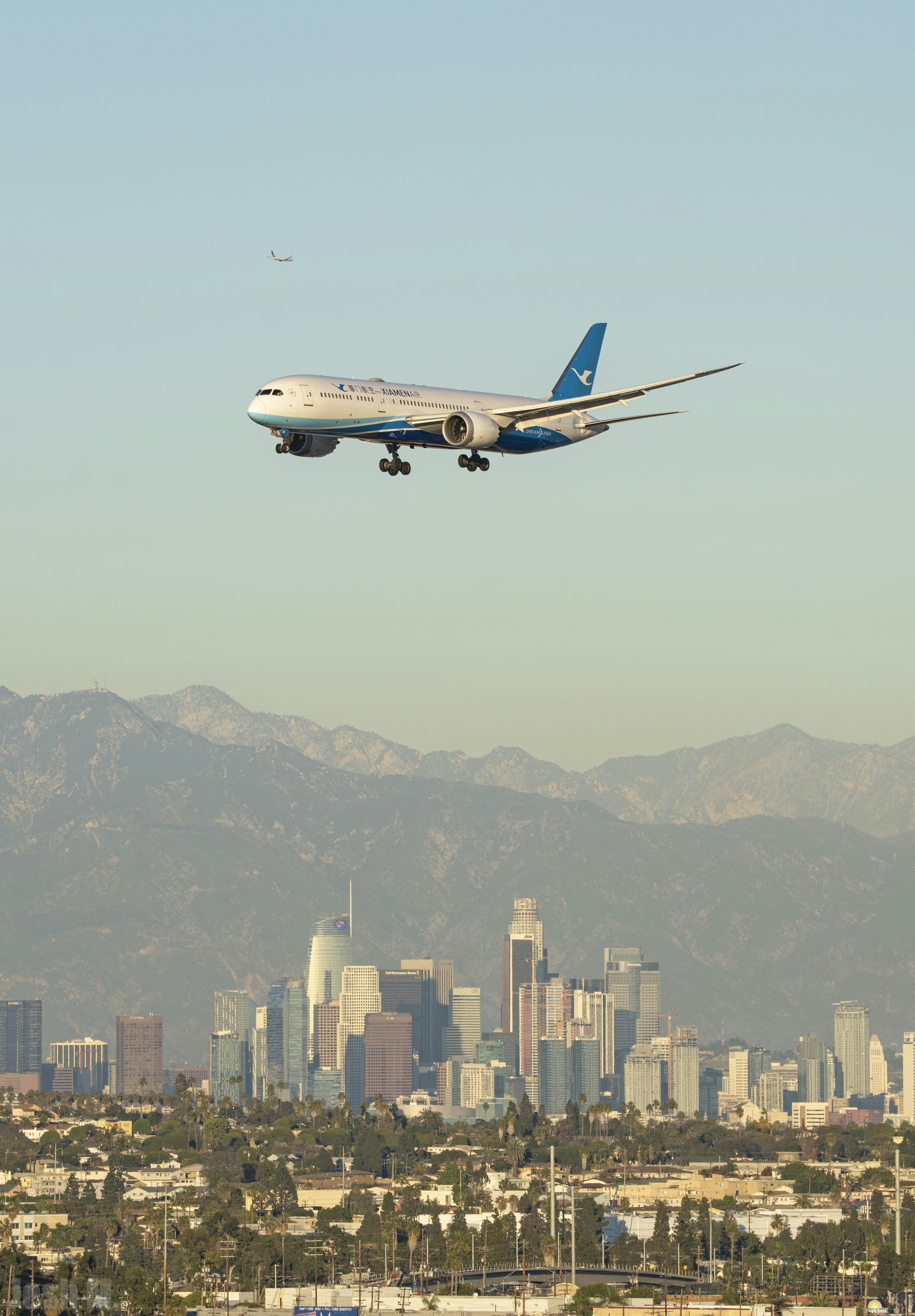White and blue passenger plane in flight over buildings photo – Free ...