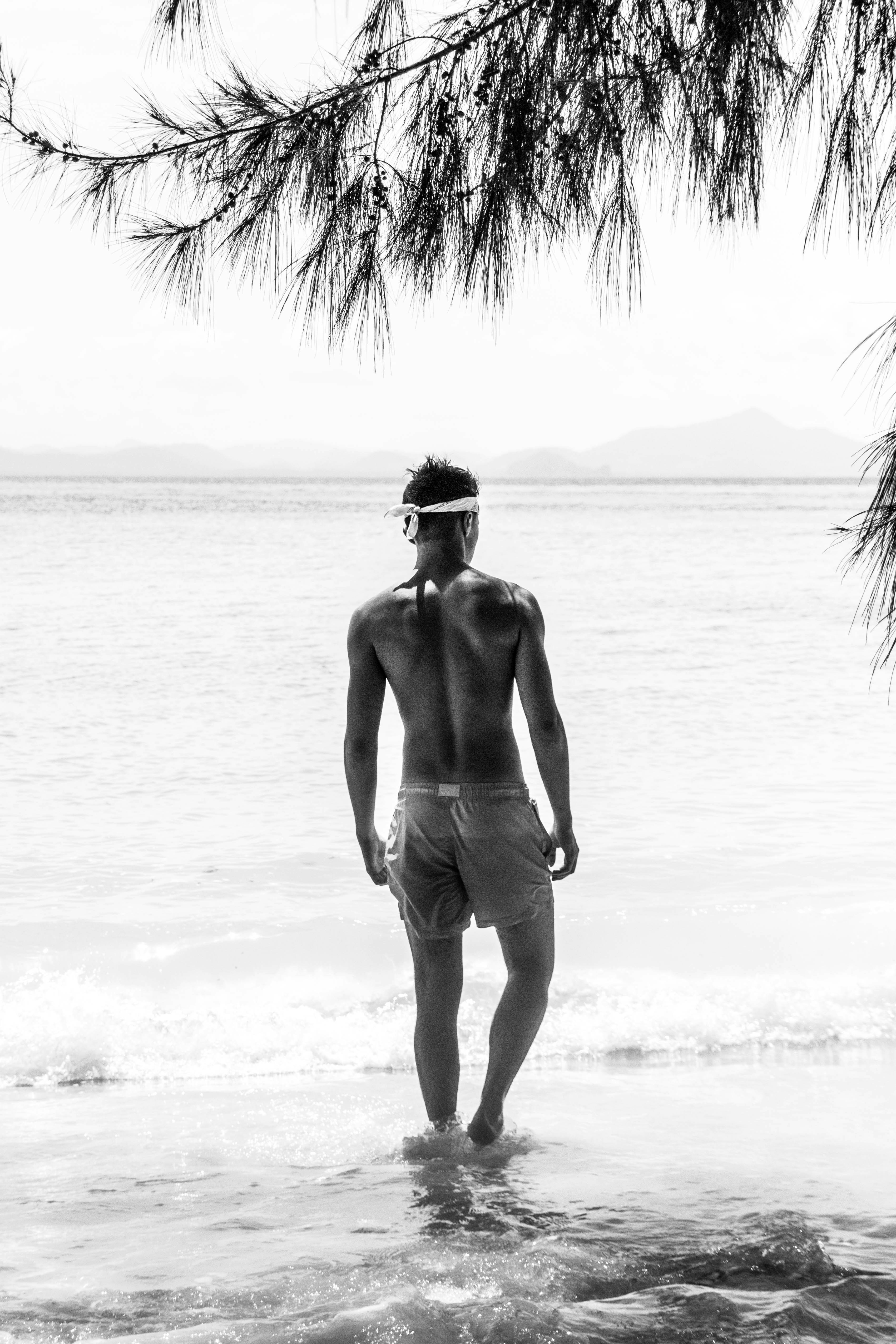 Silhouette at the Shore: A Lone Swimmer Steps Into Quiet Seas