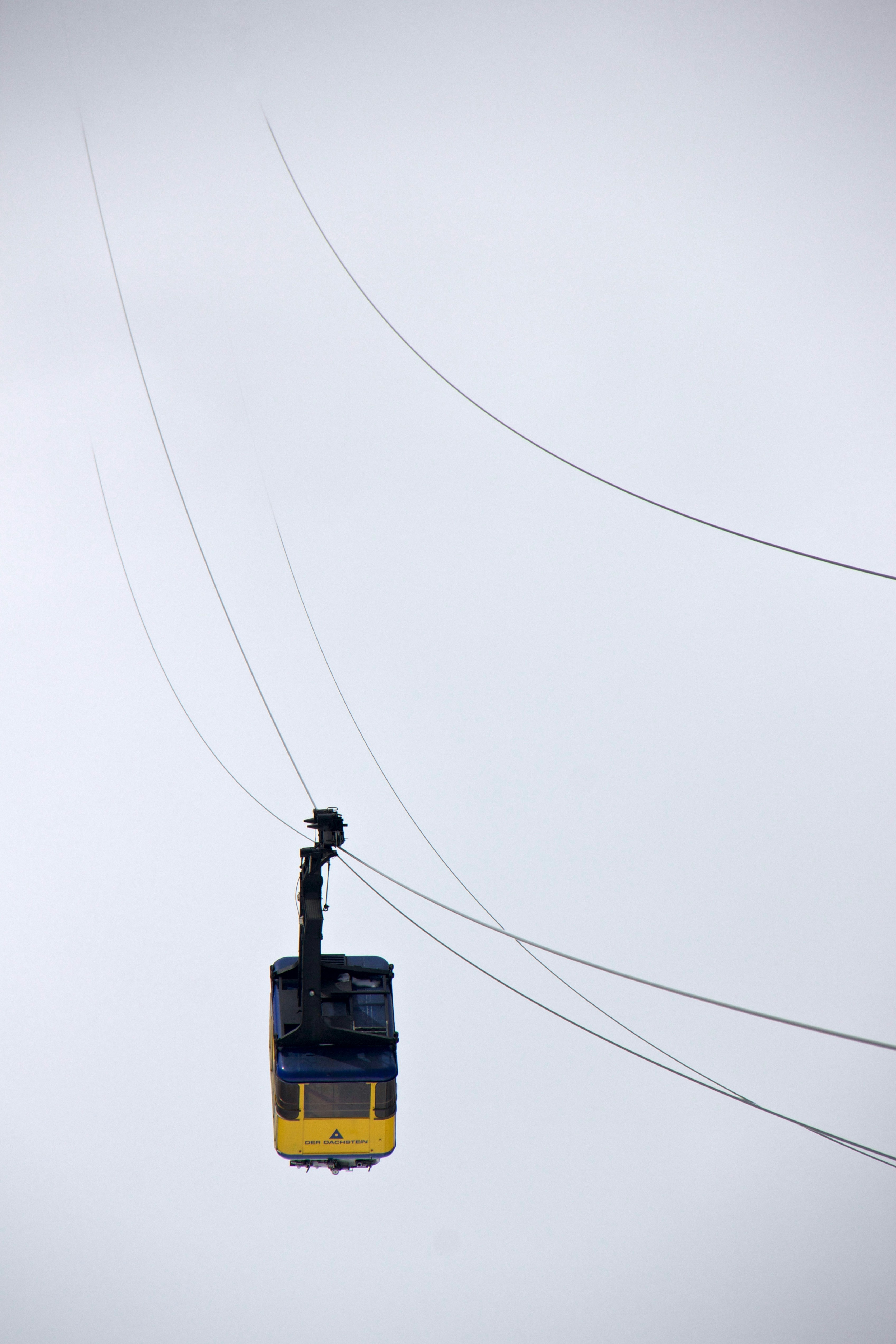 Cable car at Dachstein is going down to the foggy valley. The visibility range was quite short and from above it looked like the car goes to the great unknown. | black and yellow carnival ride