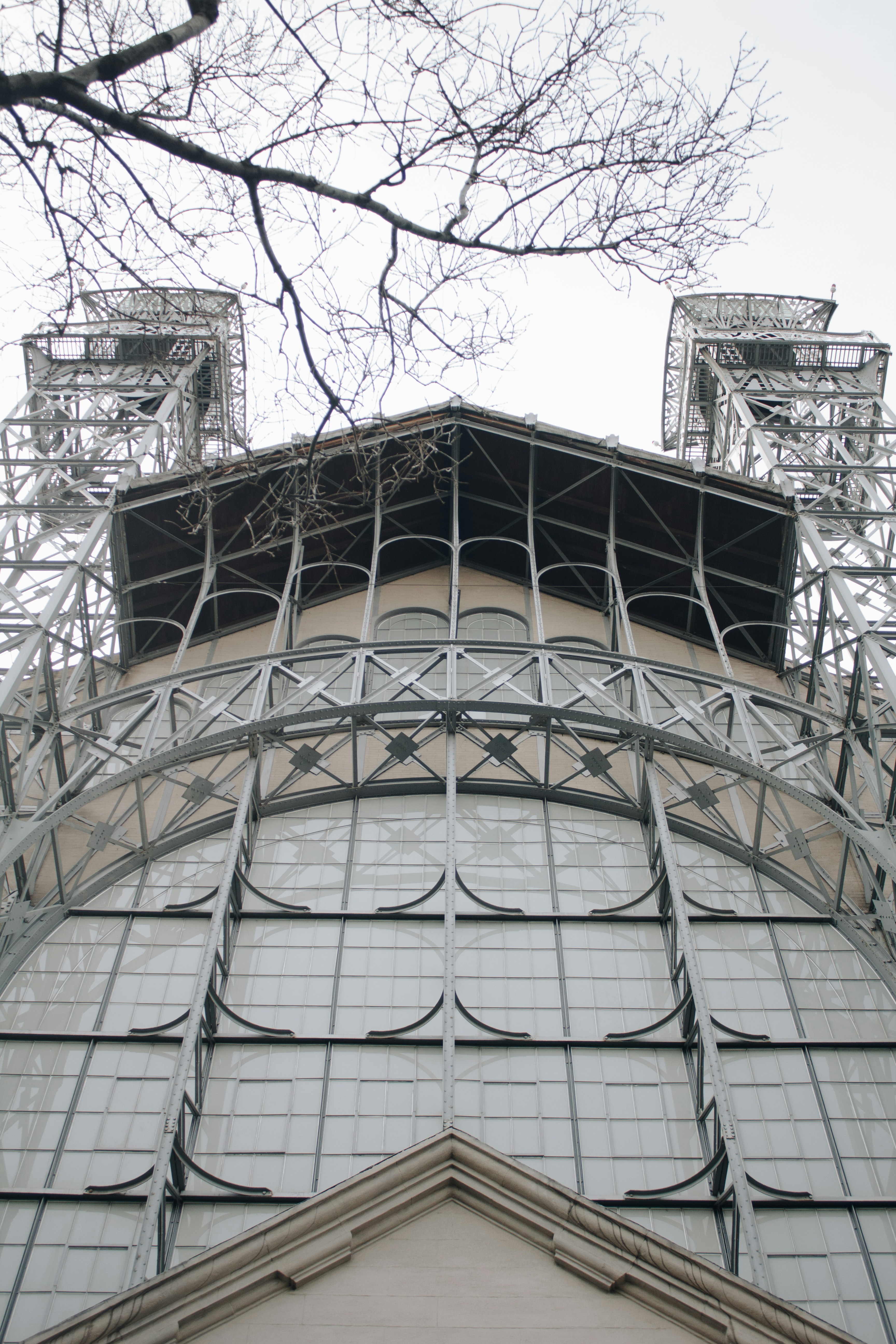 A striking view of a modern building's intricate glass and steel structure, captured from below, showcasing its unique architectural design.