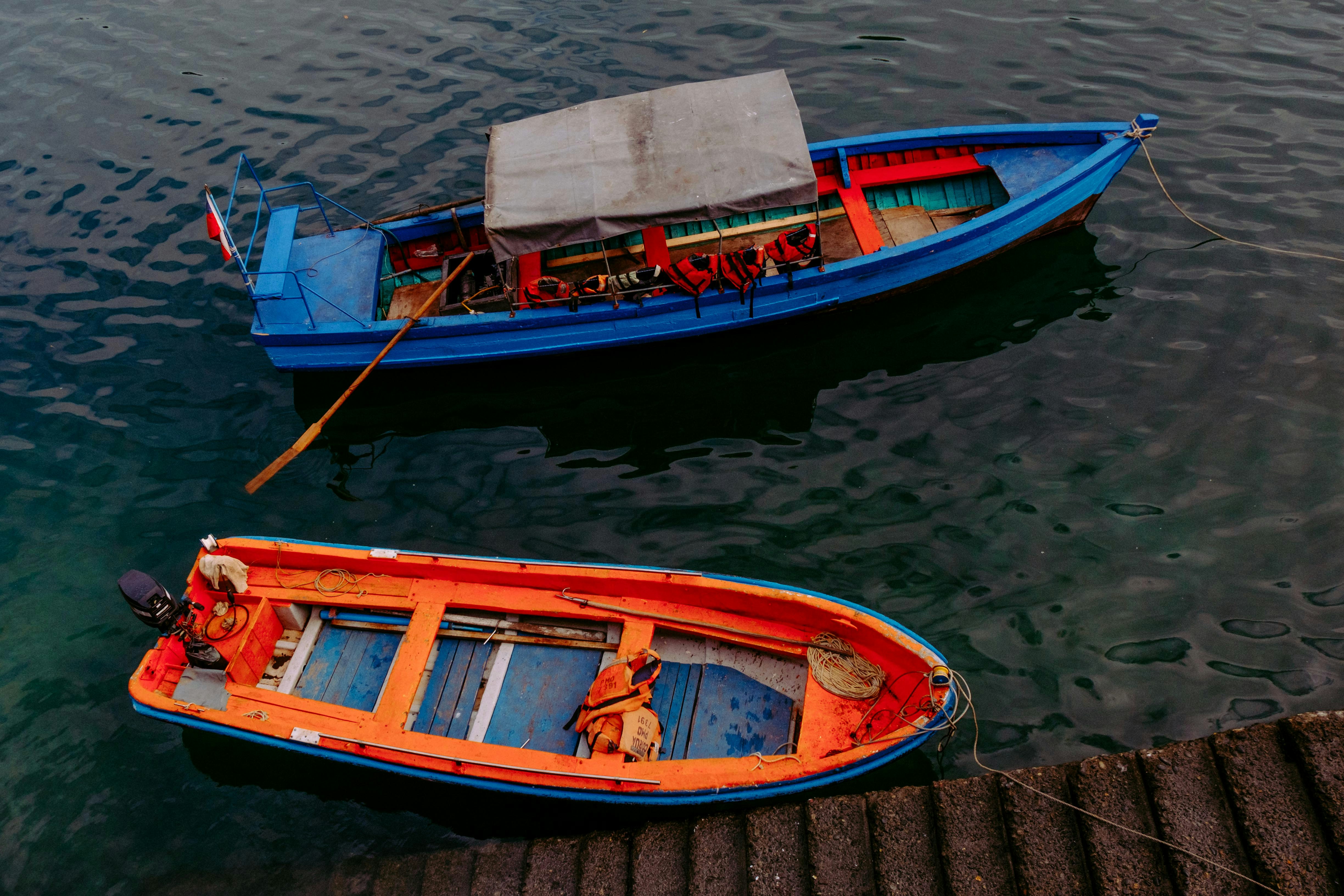 Two blue and orange boat on dock photo – Free Transportation Image on ...