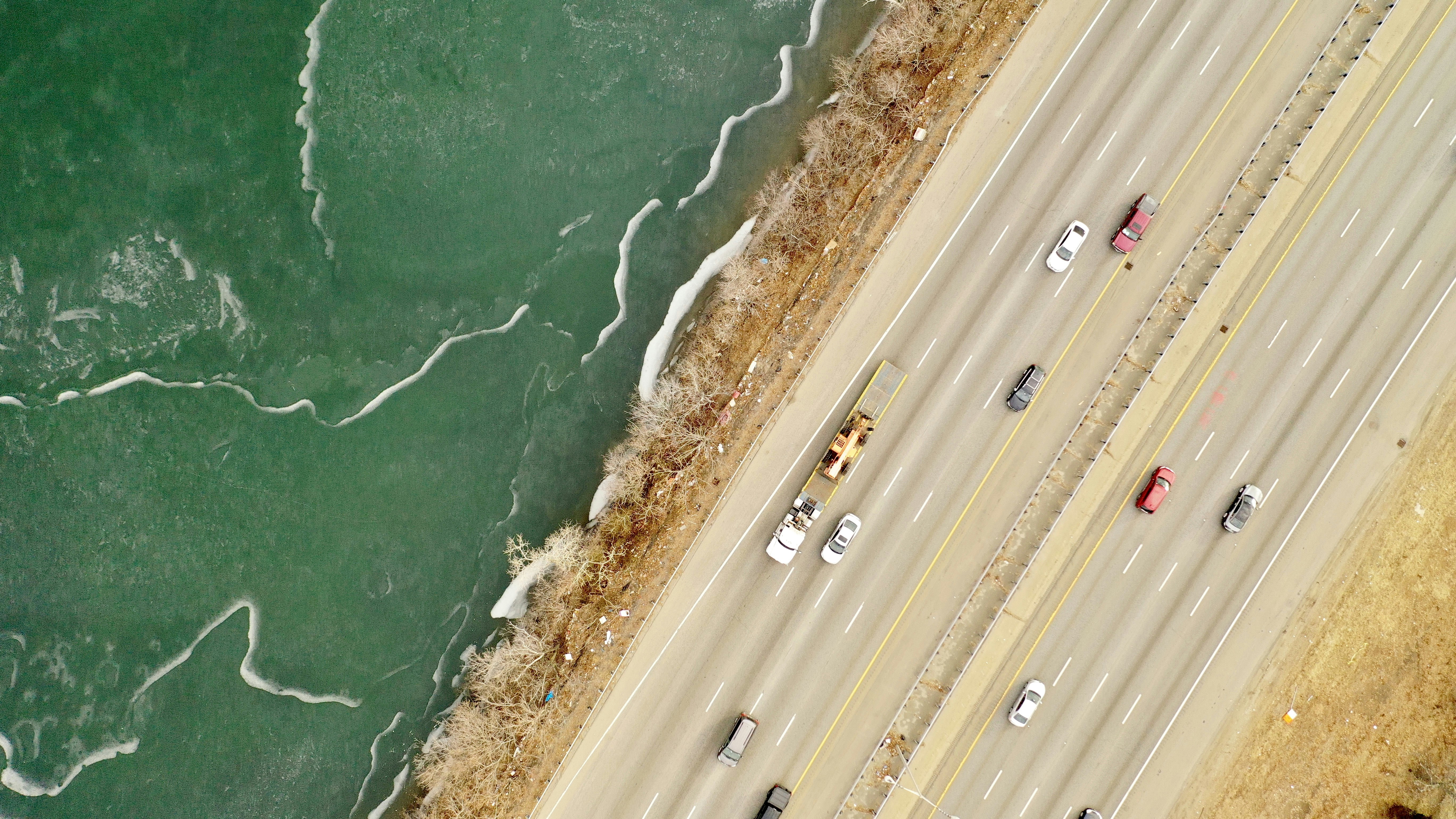 Coastline Corridor: Aerial snapshot of a sea-skimming freeway threaded with traffic