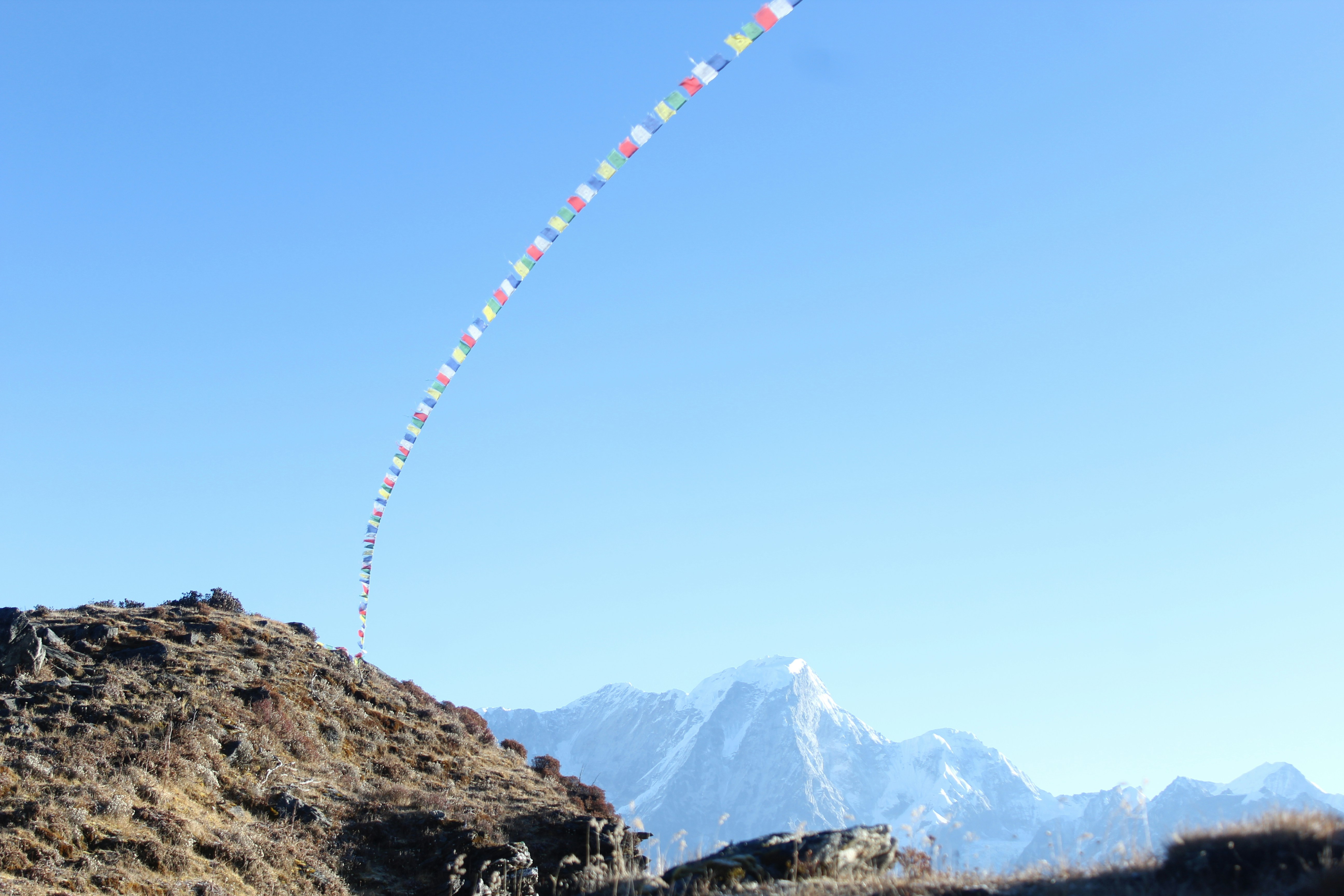 Arc of Prayer Flags Over a Snow-Dusted Himalayan Ridge