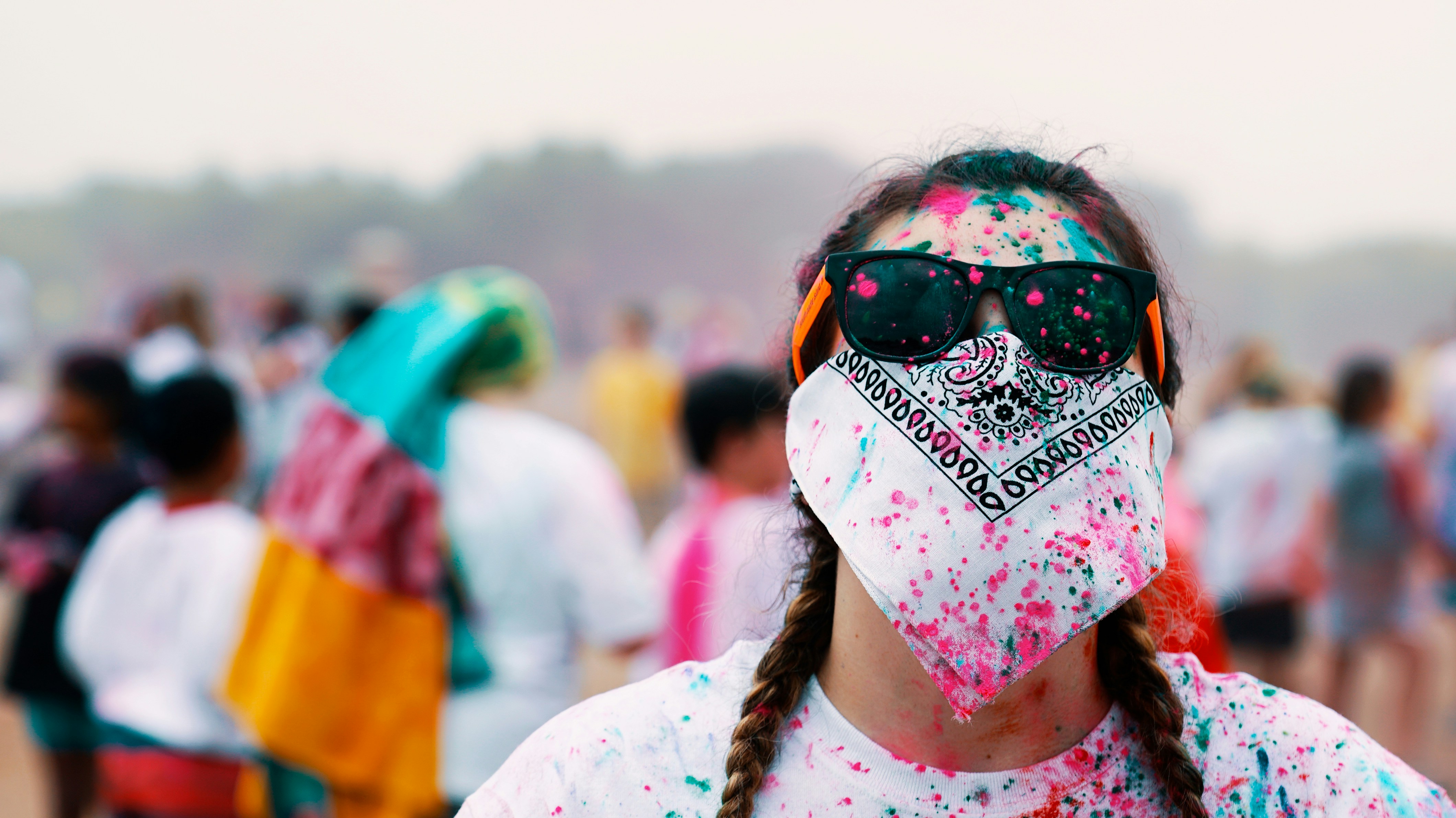 woman covering her face while playing assorted-color paints