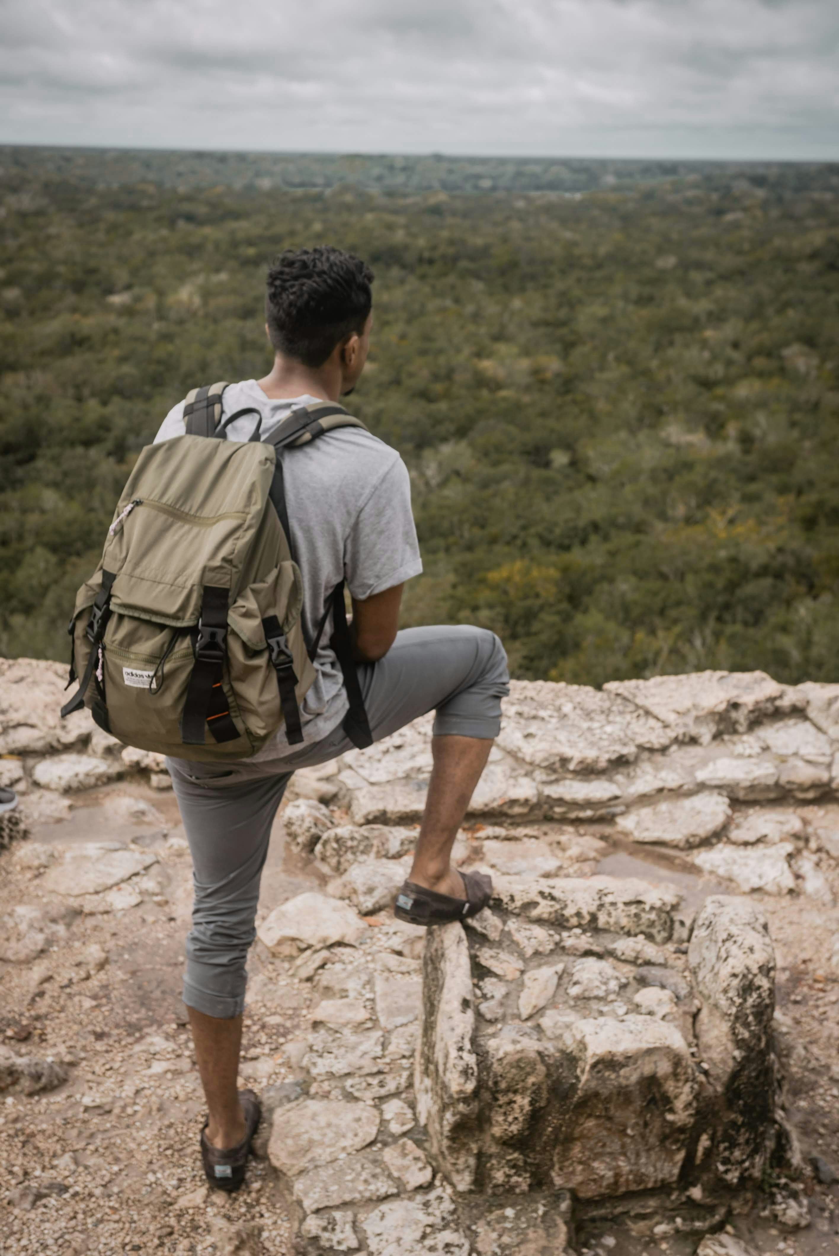 Homme avec sac à dos debout sur le rocher photo – Image gratuite de ...